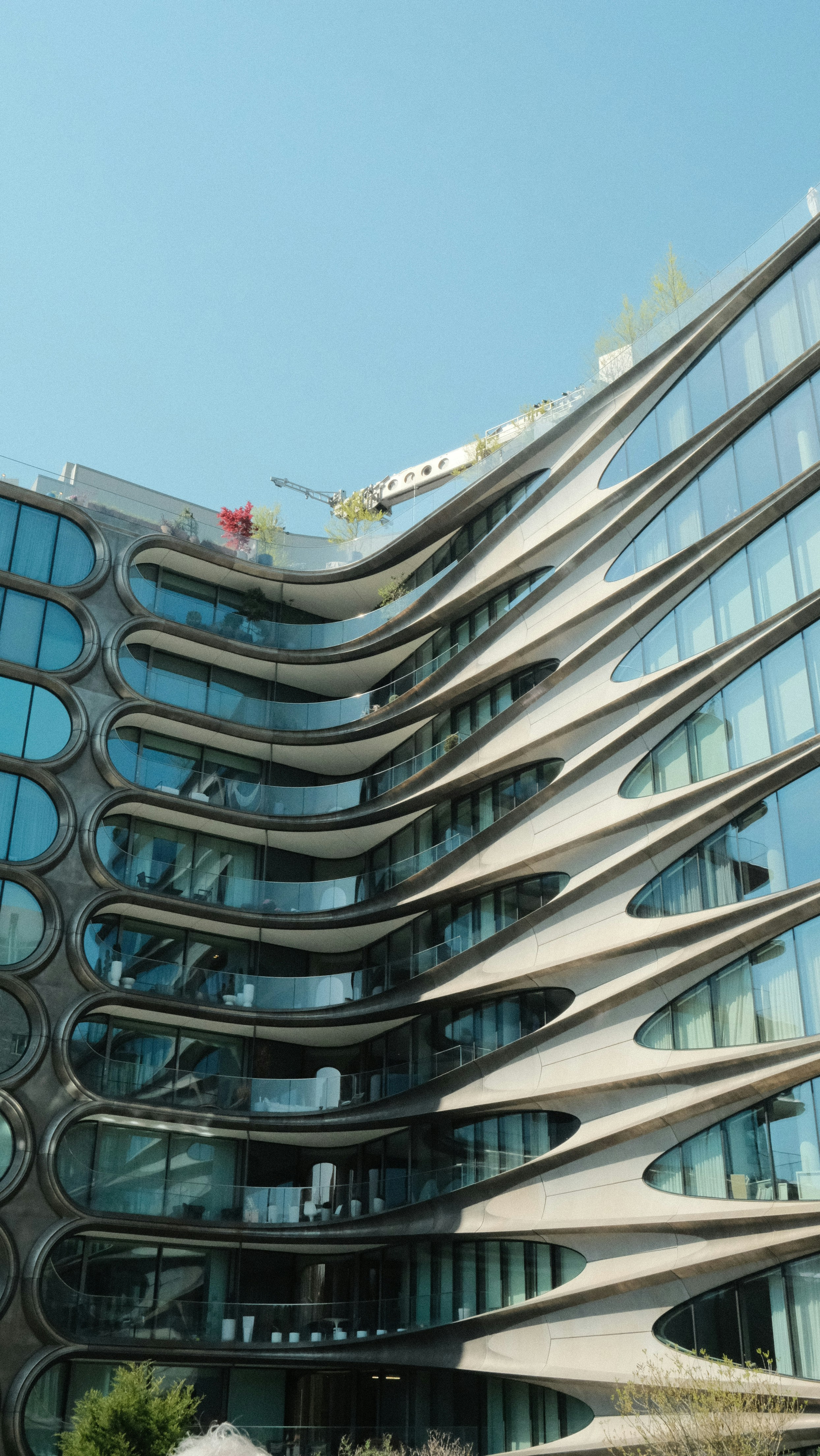 Wavy Facade: Concrete Curves Clad in Glass Against a Clear Sky