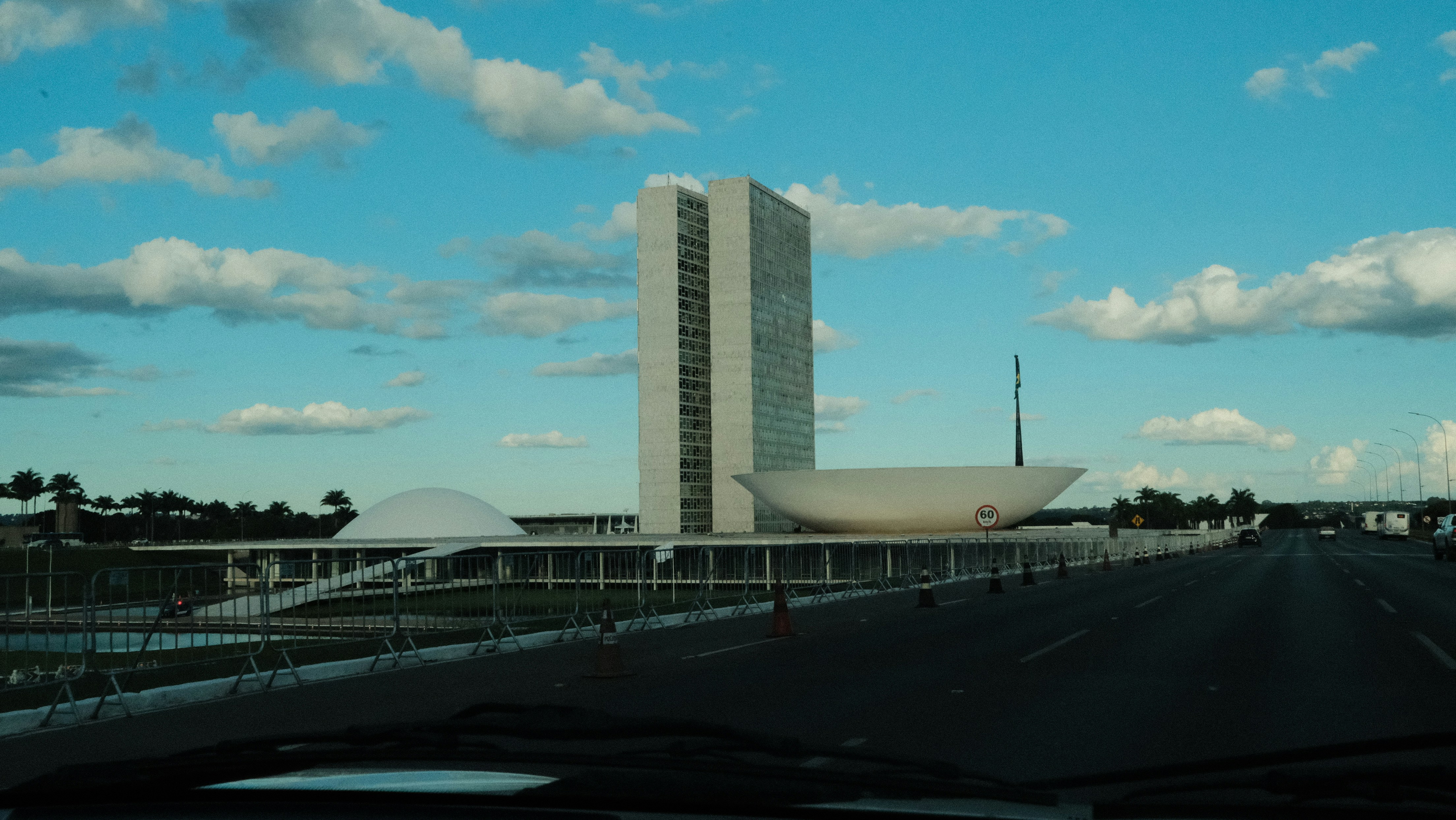 Concrete Horizon: City Edge and Modern Wing Rising Above the Road