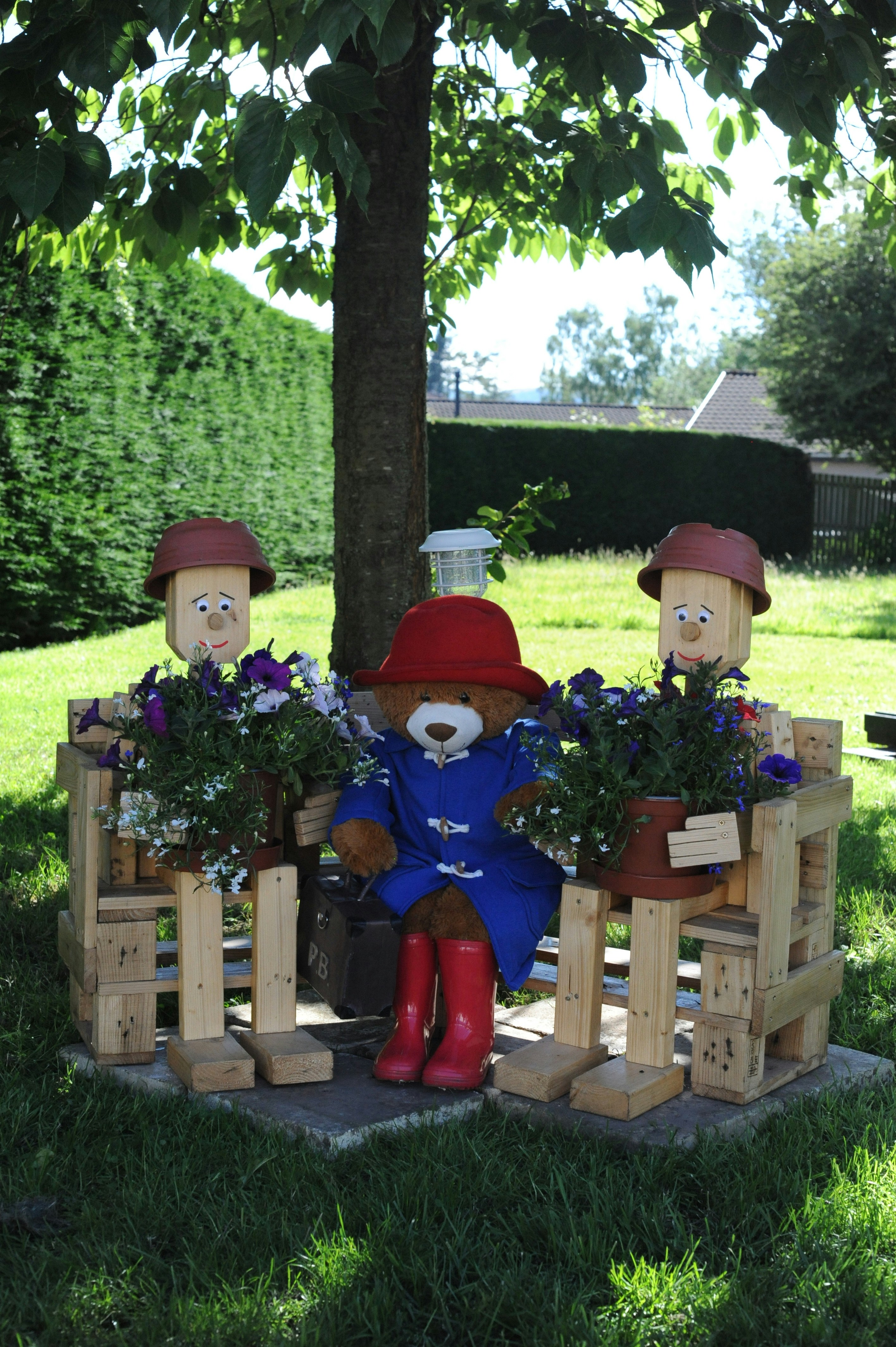 Wooden Flower Seats and Plush Bear under Dappled Shade