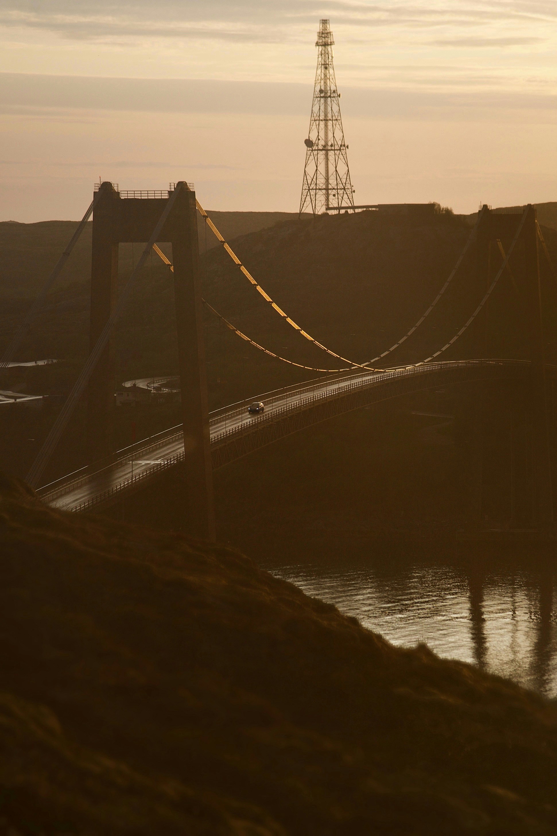 Golden Hour Suspension: A Lone Car on the Quiet Bridge