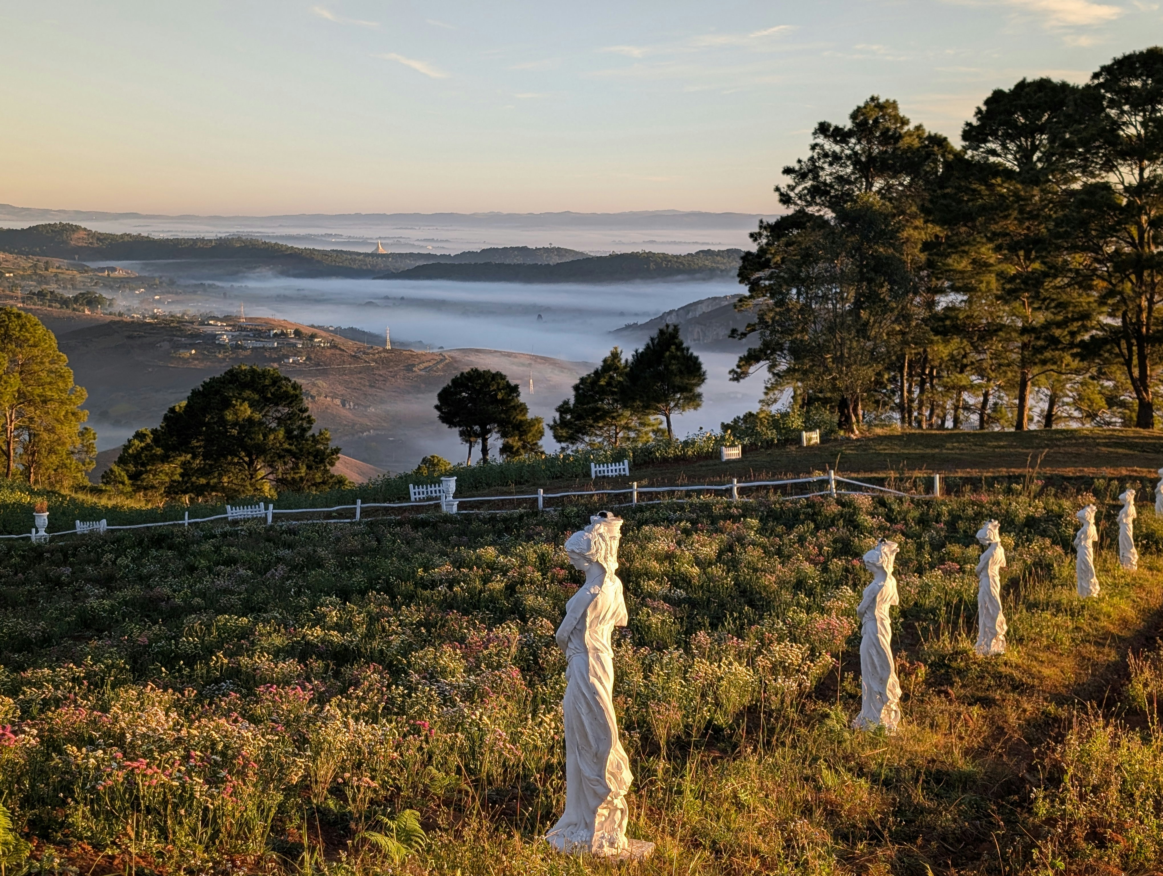 Sunlit Path Through a Misty Terrace of Statues