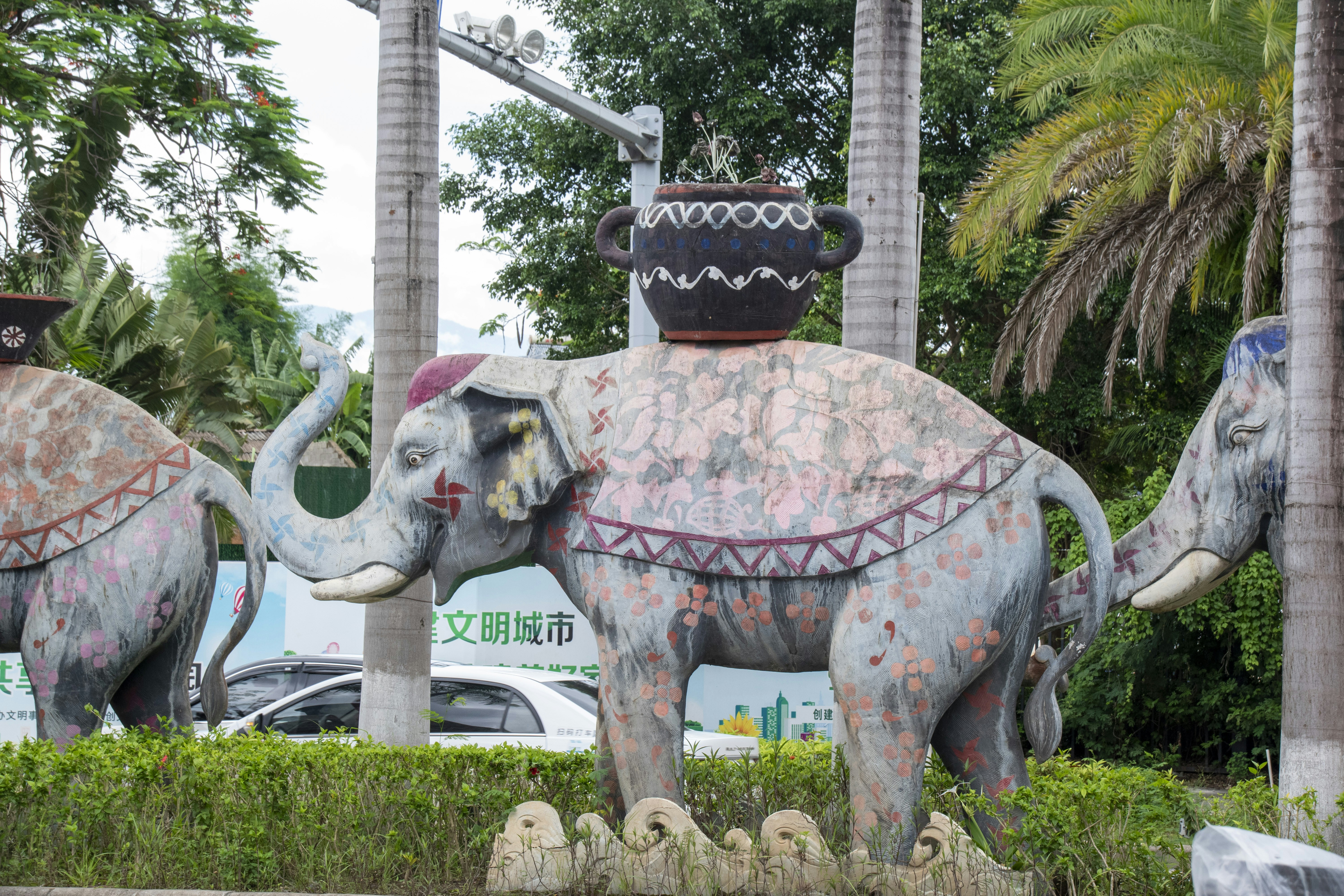 Trumpeting Trance: A Trio of Painted Elephants Guard a Tropical Roundabout