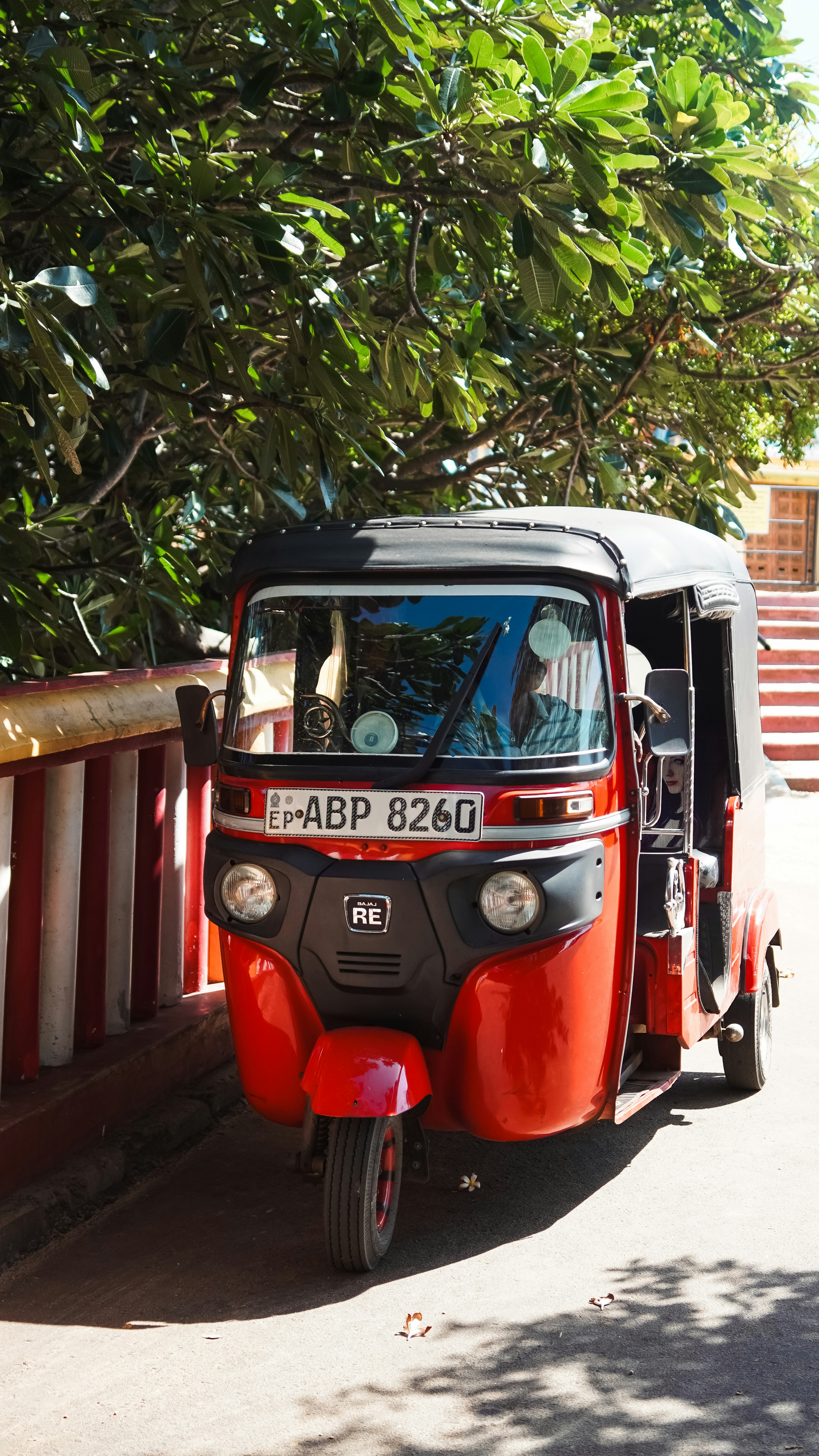 Red Tuk-Tuk Emerges from the Shade