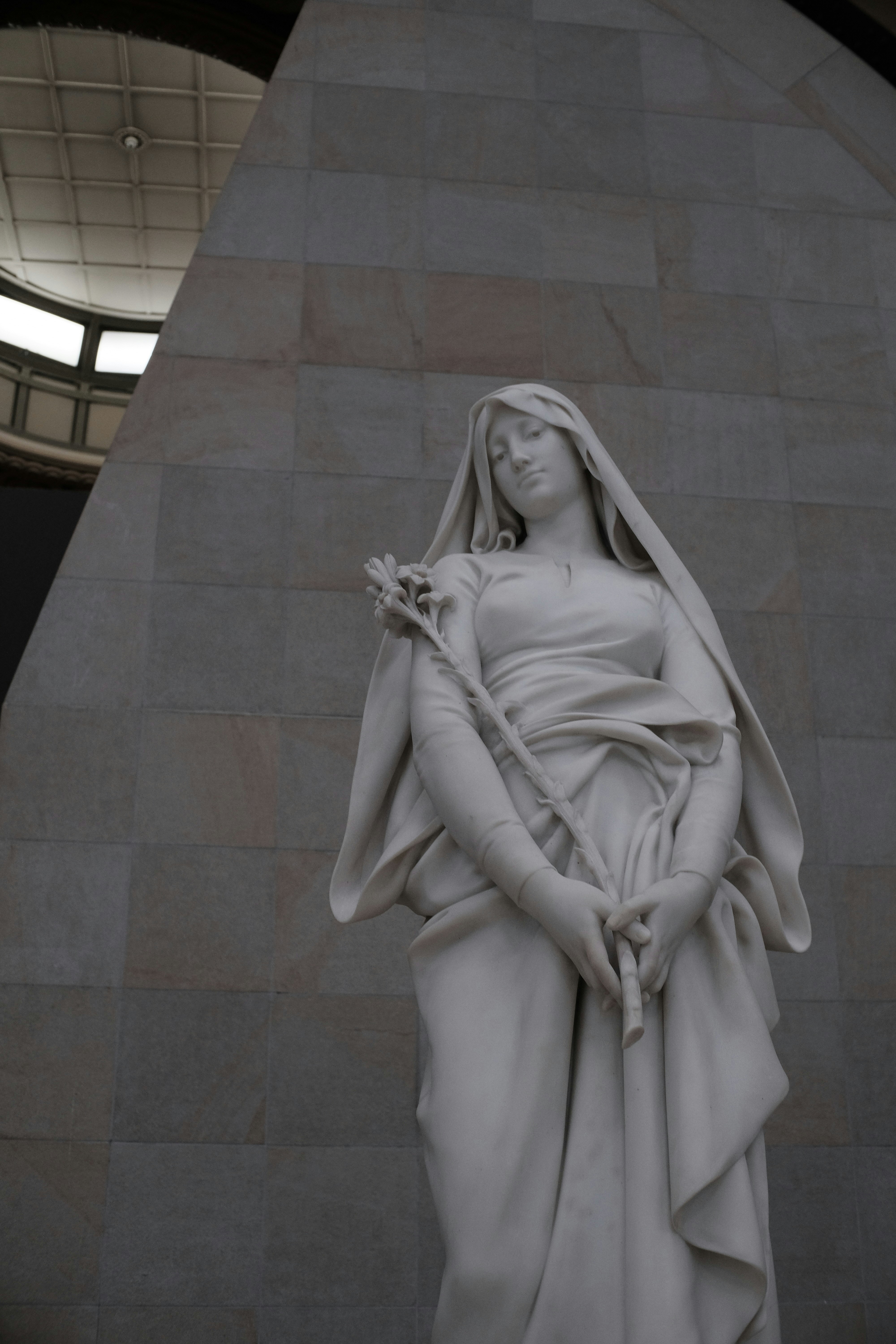 Silent Guardian in Marble: Veil and Staff Against Stone Arch