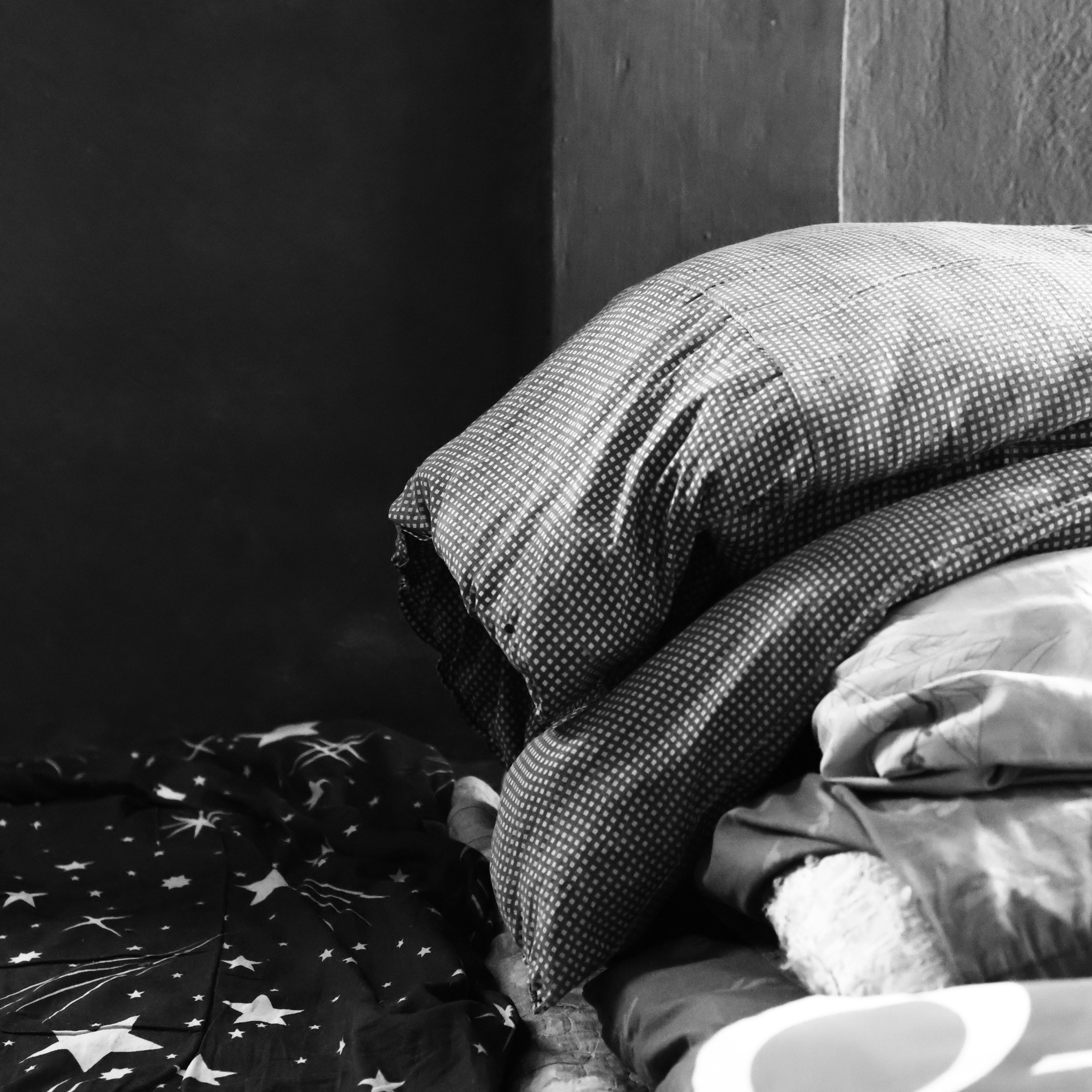Piled pillows on a monochrome bed
