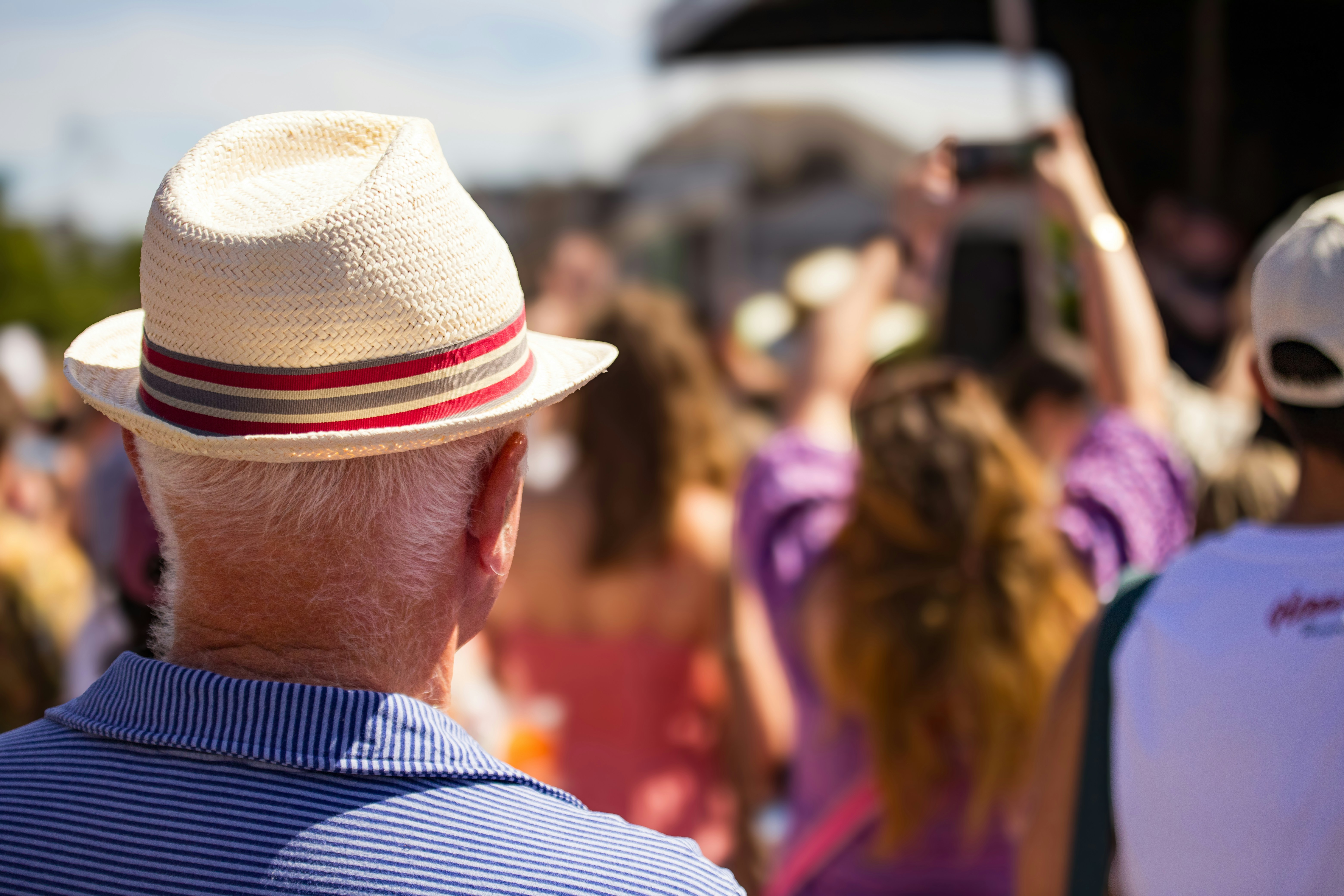 Back Row Anthem: The Crowd Faces Forward in a Sunlit Outdoor Gathering