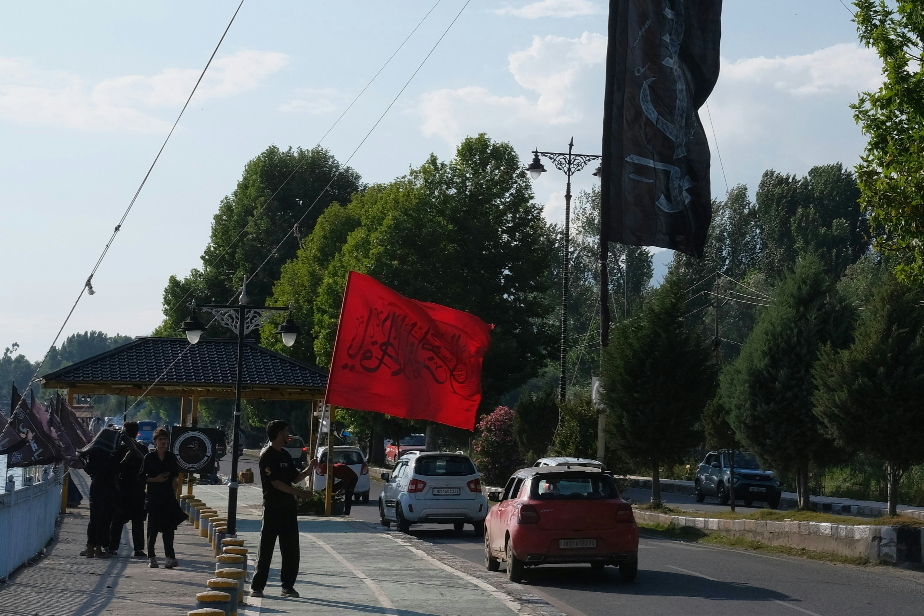 Flag Bearer and Red Banner Lead the Street Procession