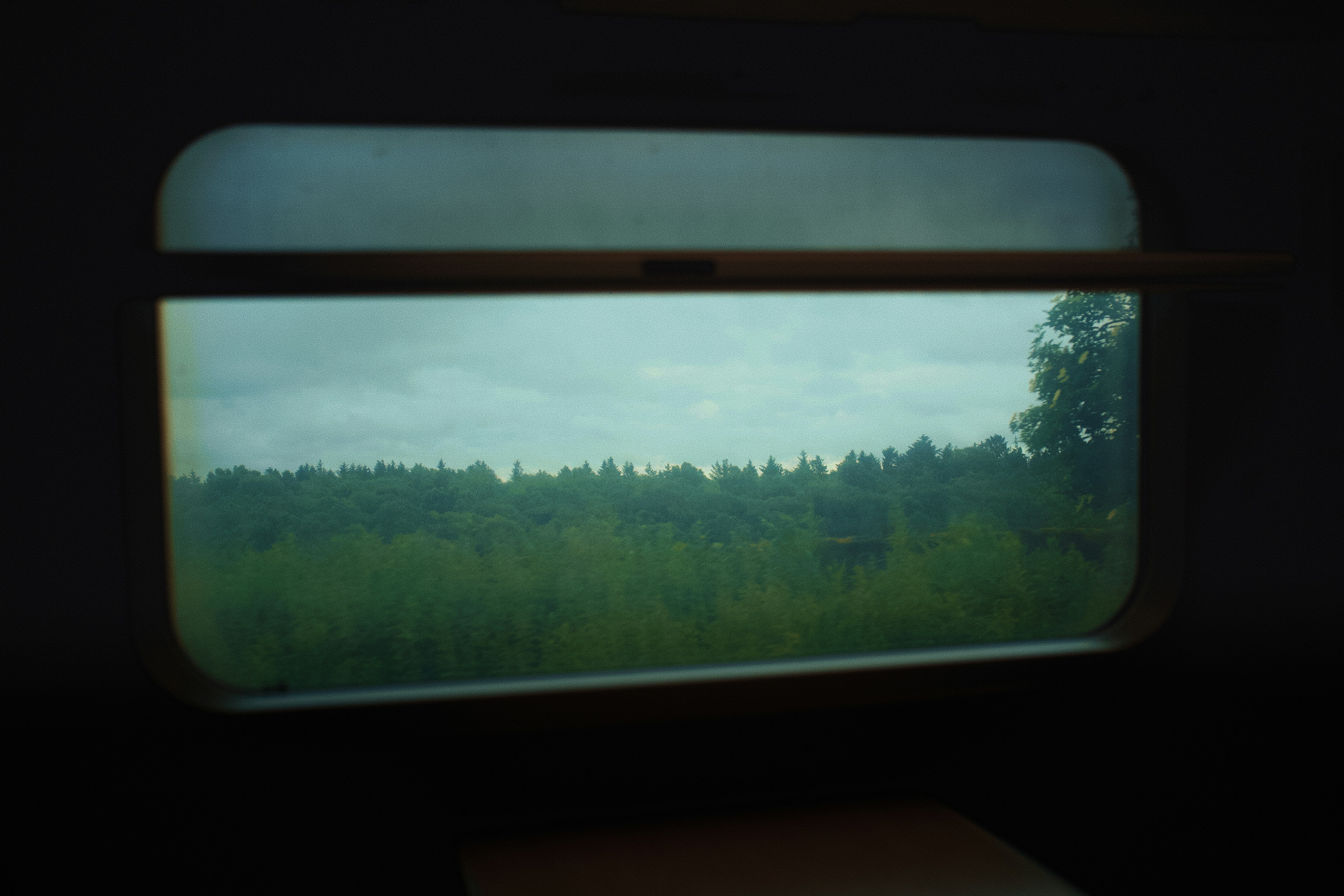 Green Valley Through a Narrow Window: A Quiet Landscape Framed by Darkness