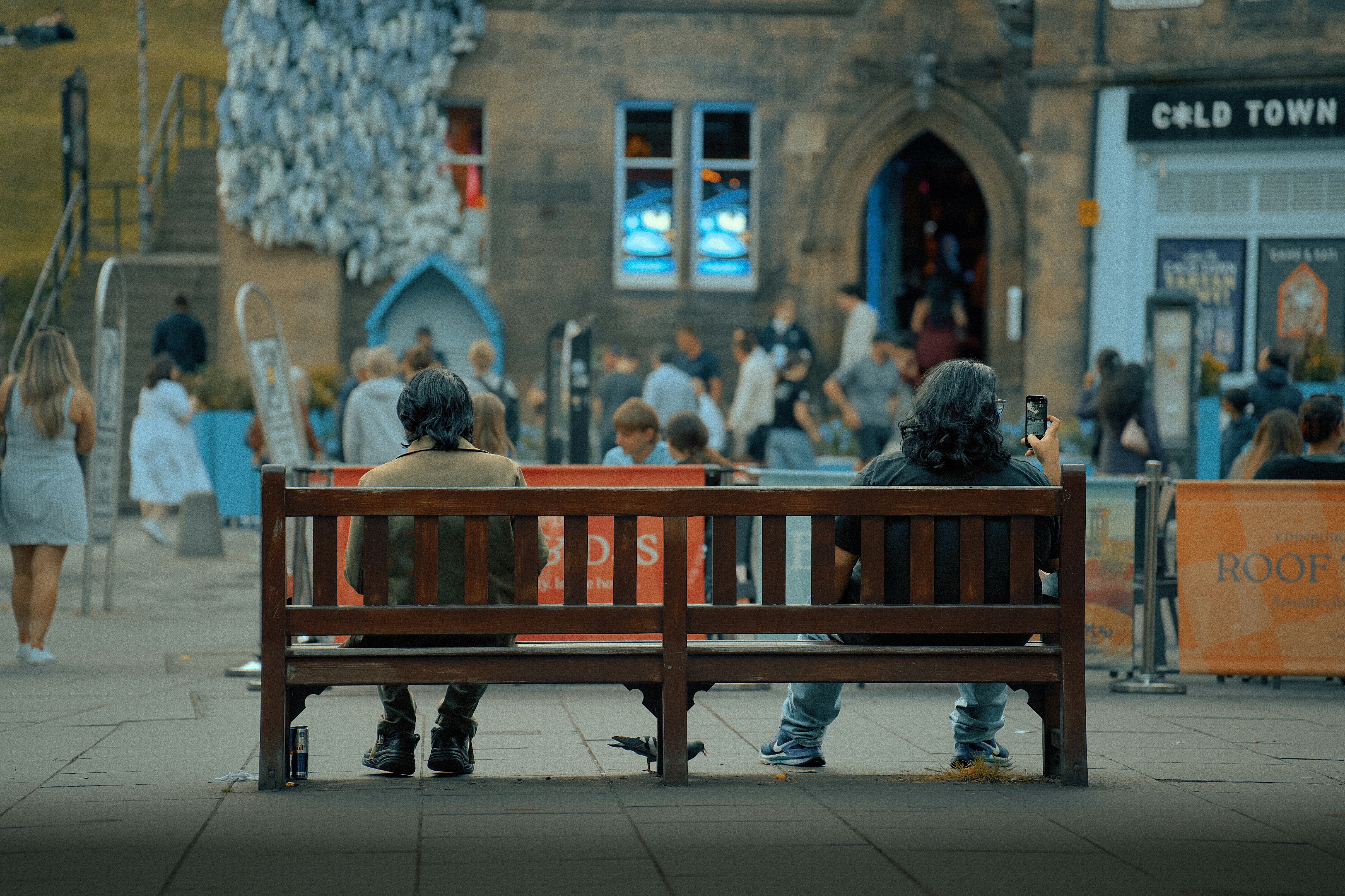 Couple on a Shared Bench Overlooking a Busy Street