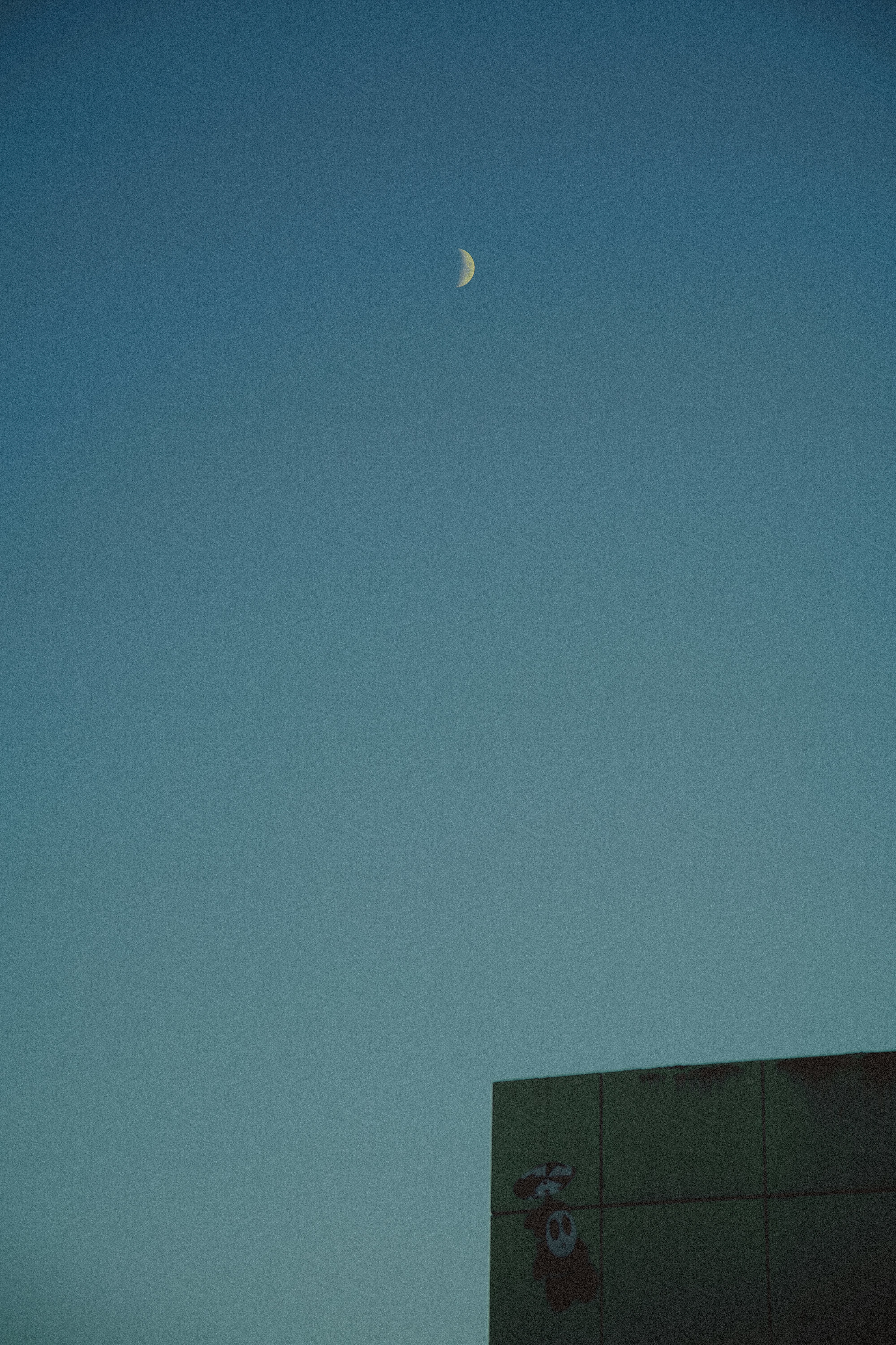 Moon Between Sky and Cube: A Quiet Urban Evening