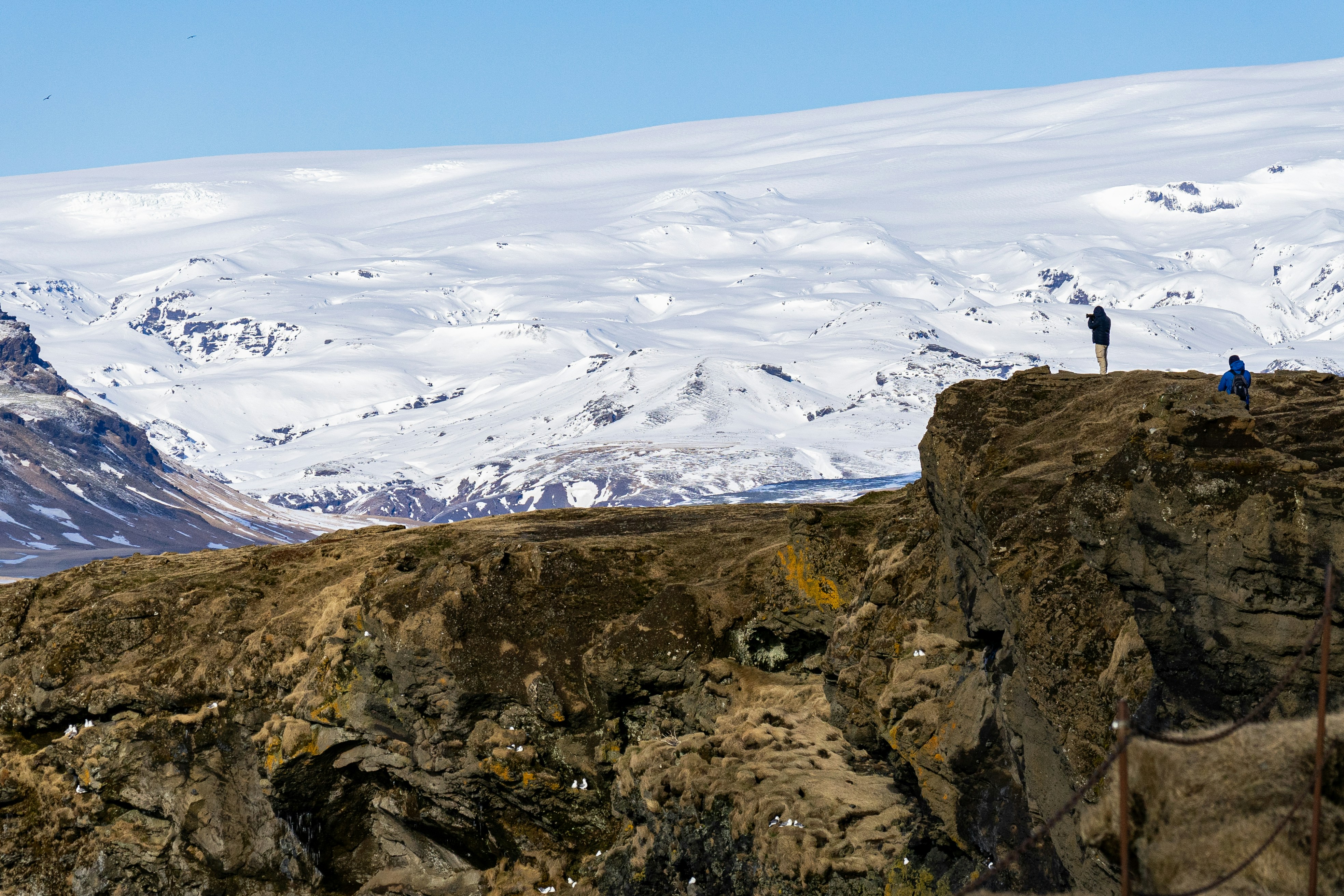 Snowbound Rim: Climbers at the Edge of a basalt Cliff