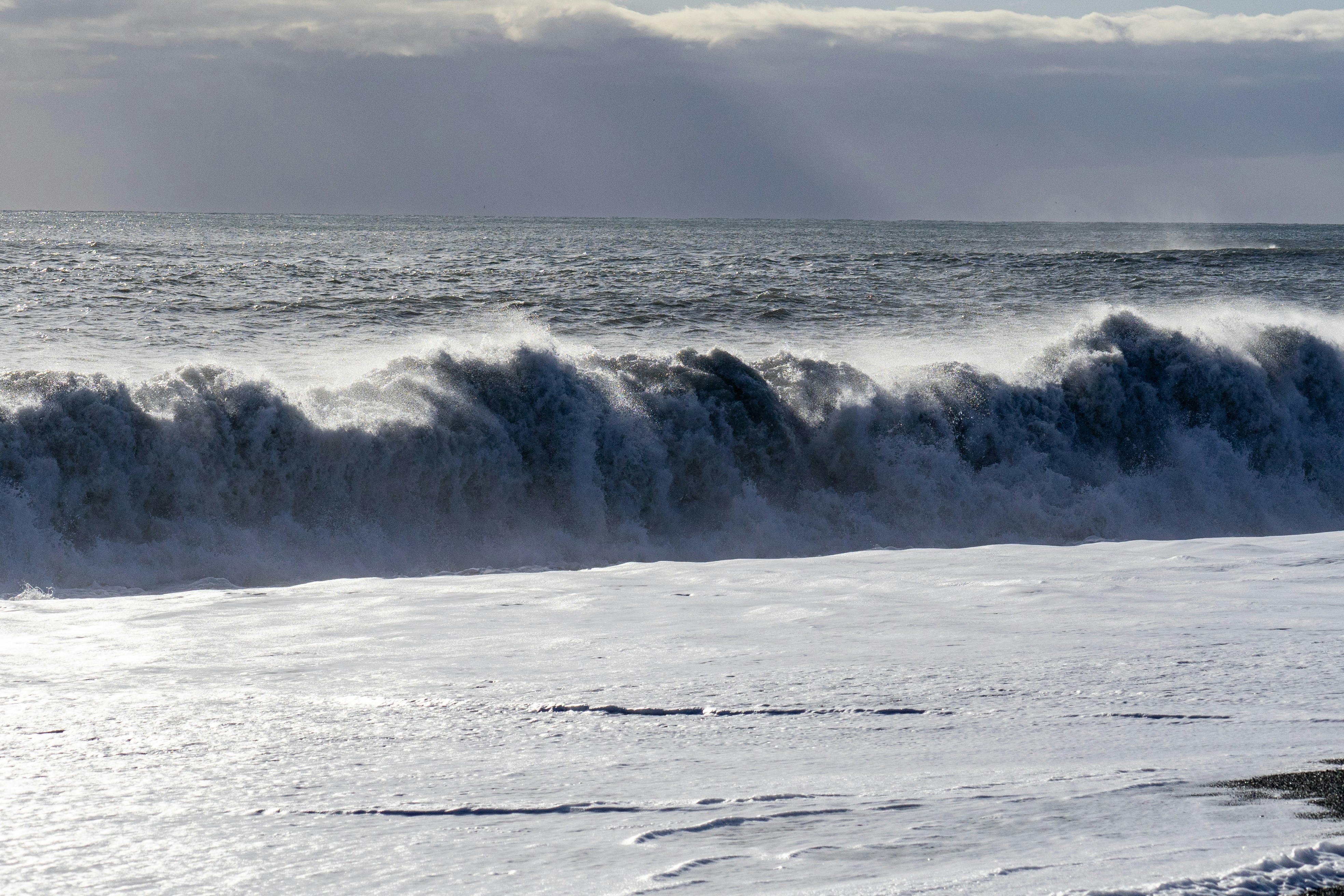 Rough Wake: A Cresting Ocean Break Under Overcast Skies