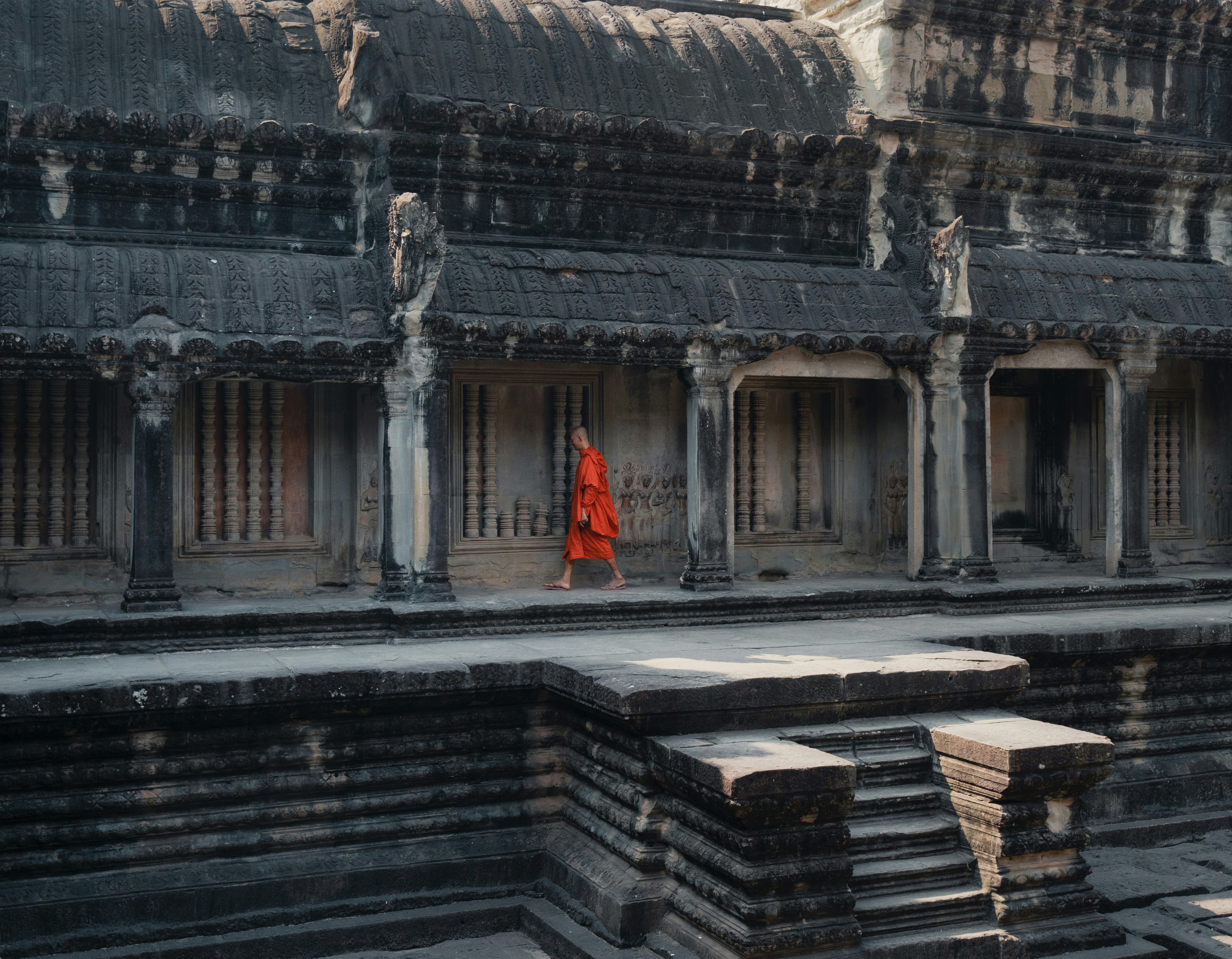 Red-robed traveler on ancient temple ledge