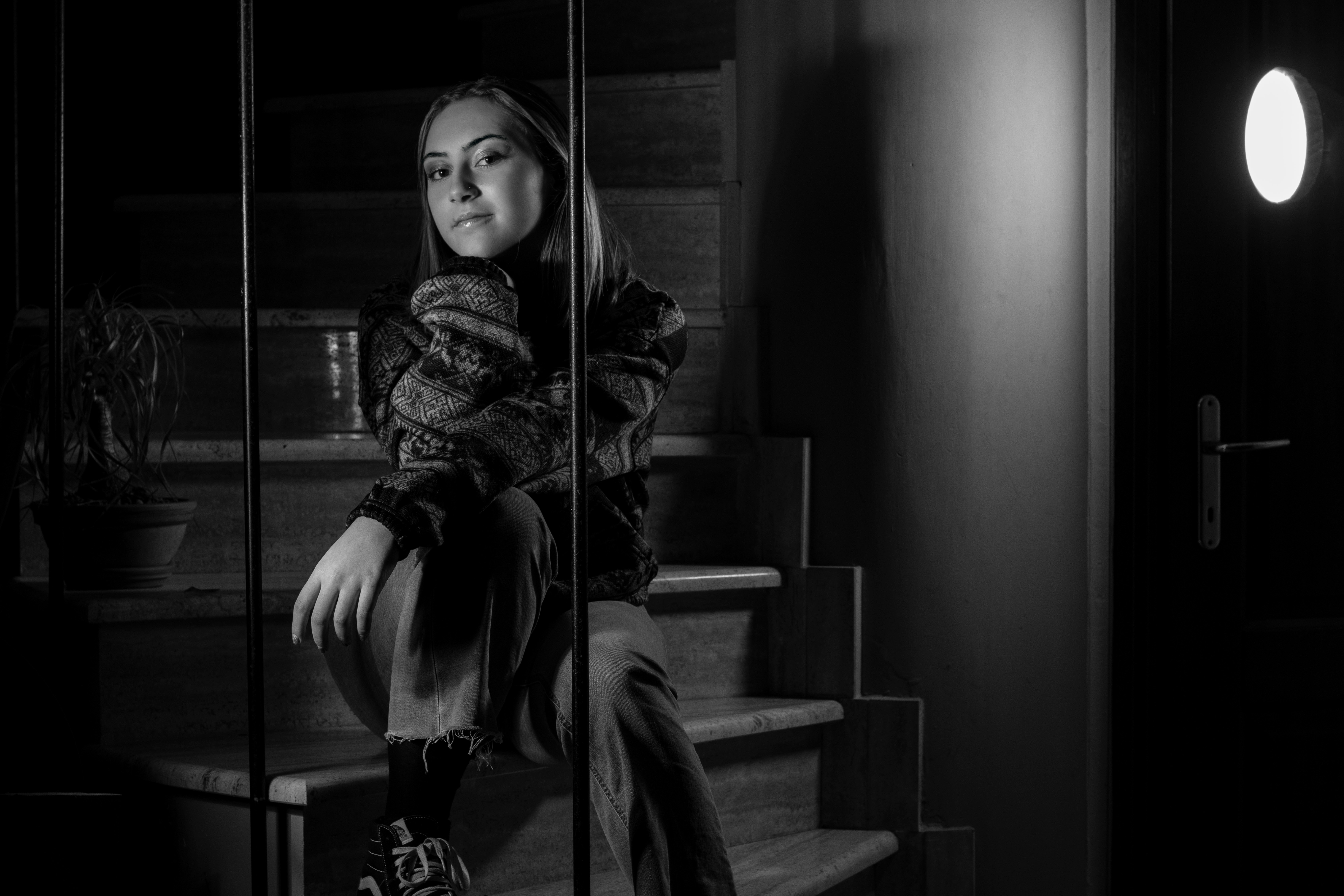 Solitary Moment on Stairs: A Quiet Gaze Through Glass