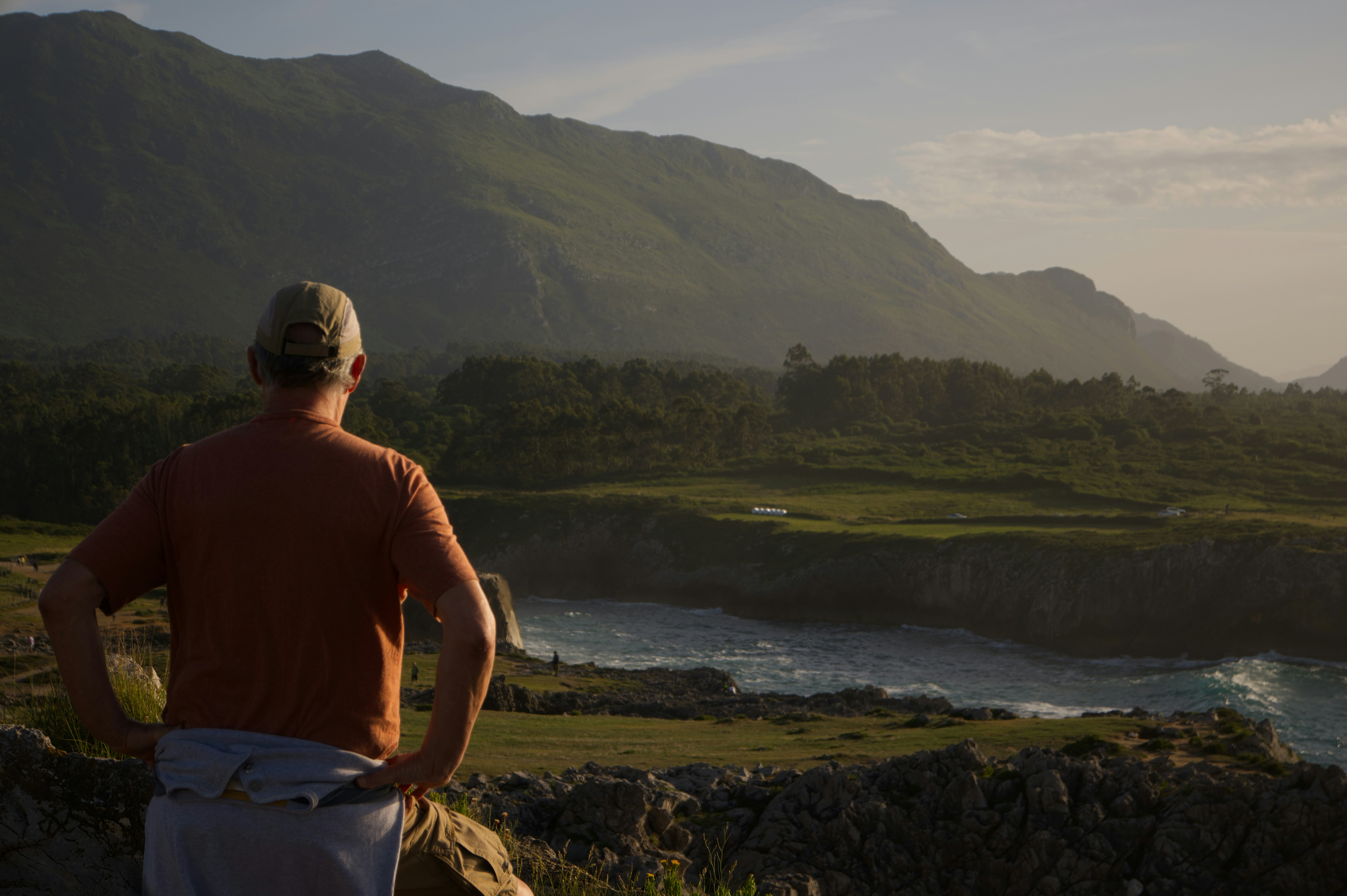 A man views a scenic coastal golf course with mountains. photo – Free ...
