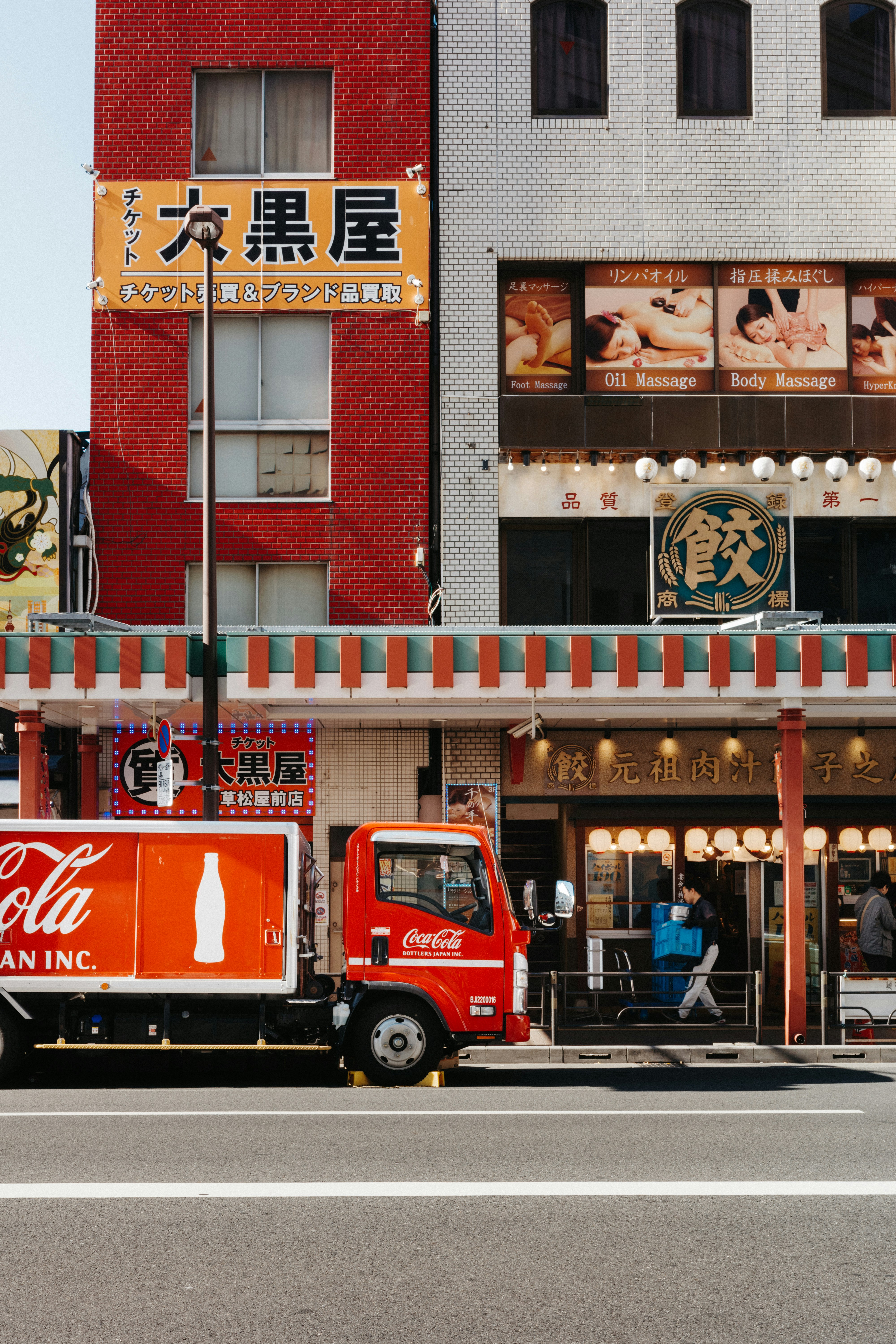 Bright Red Drum and Billboards: A Slice of Tokyo Street Commerce
