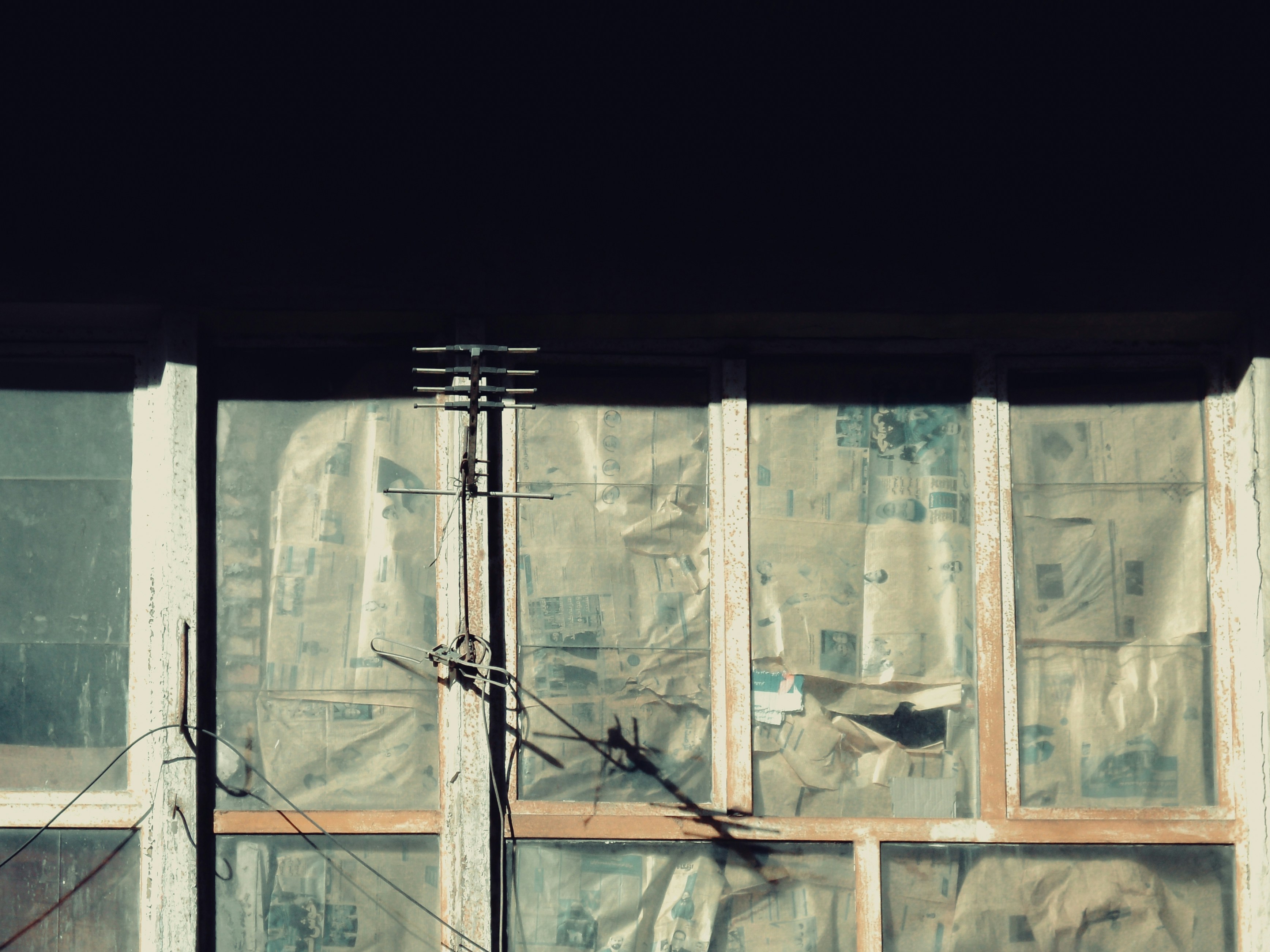 Weathered Window Light: Abstract Urban Facade and TV Antenna