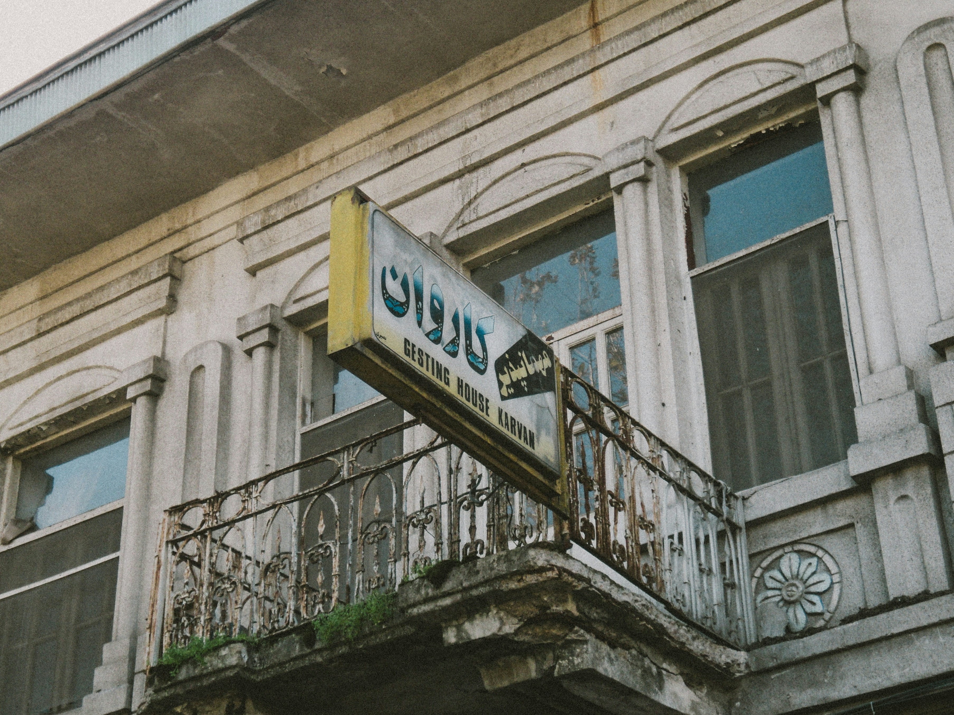 The rusty balcony still waits for travelers who never returned.