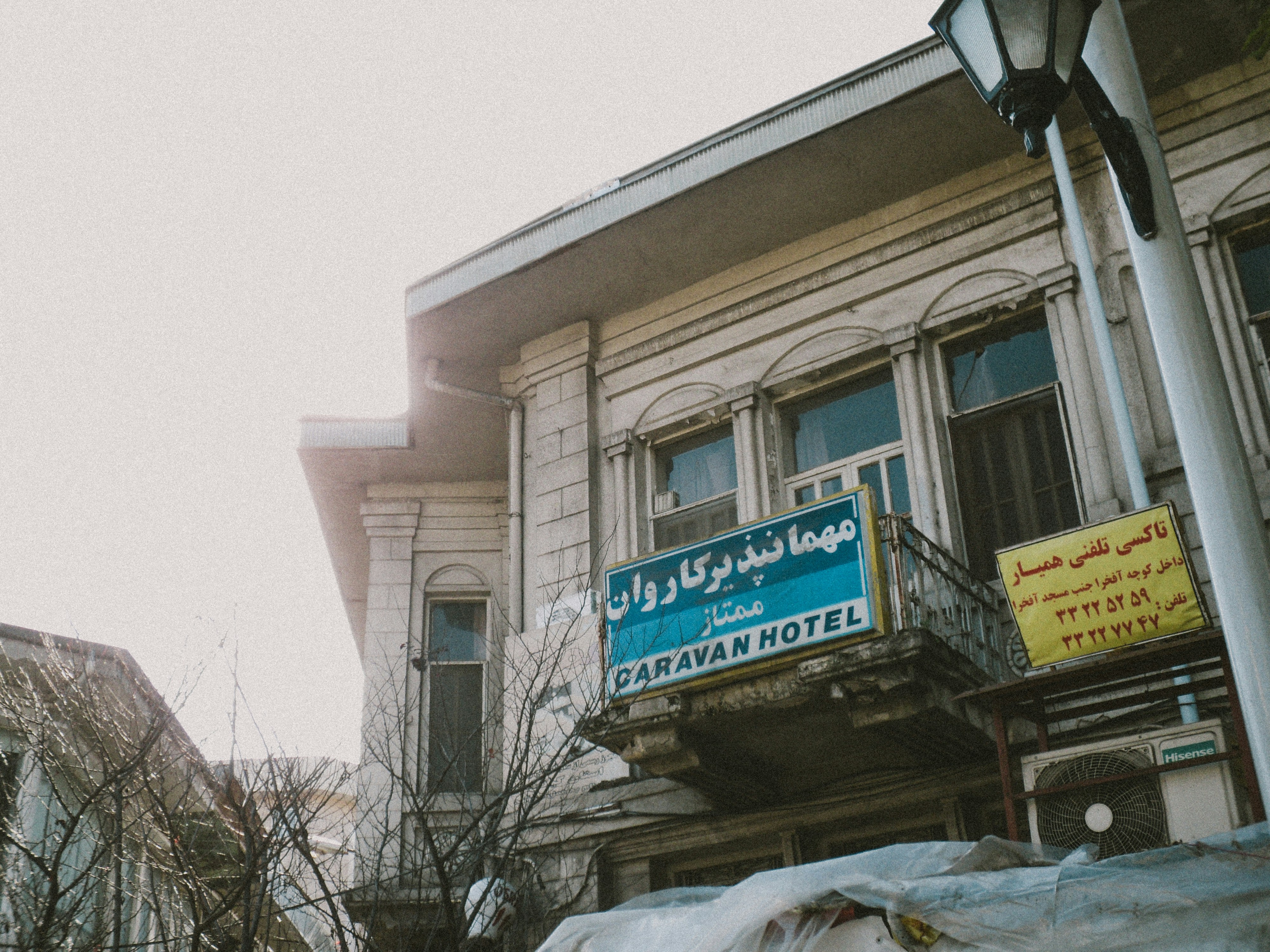 Neon Sign and Balcony Over Carved Facade