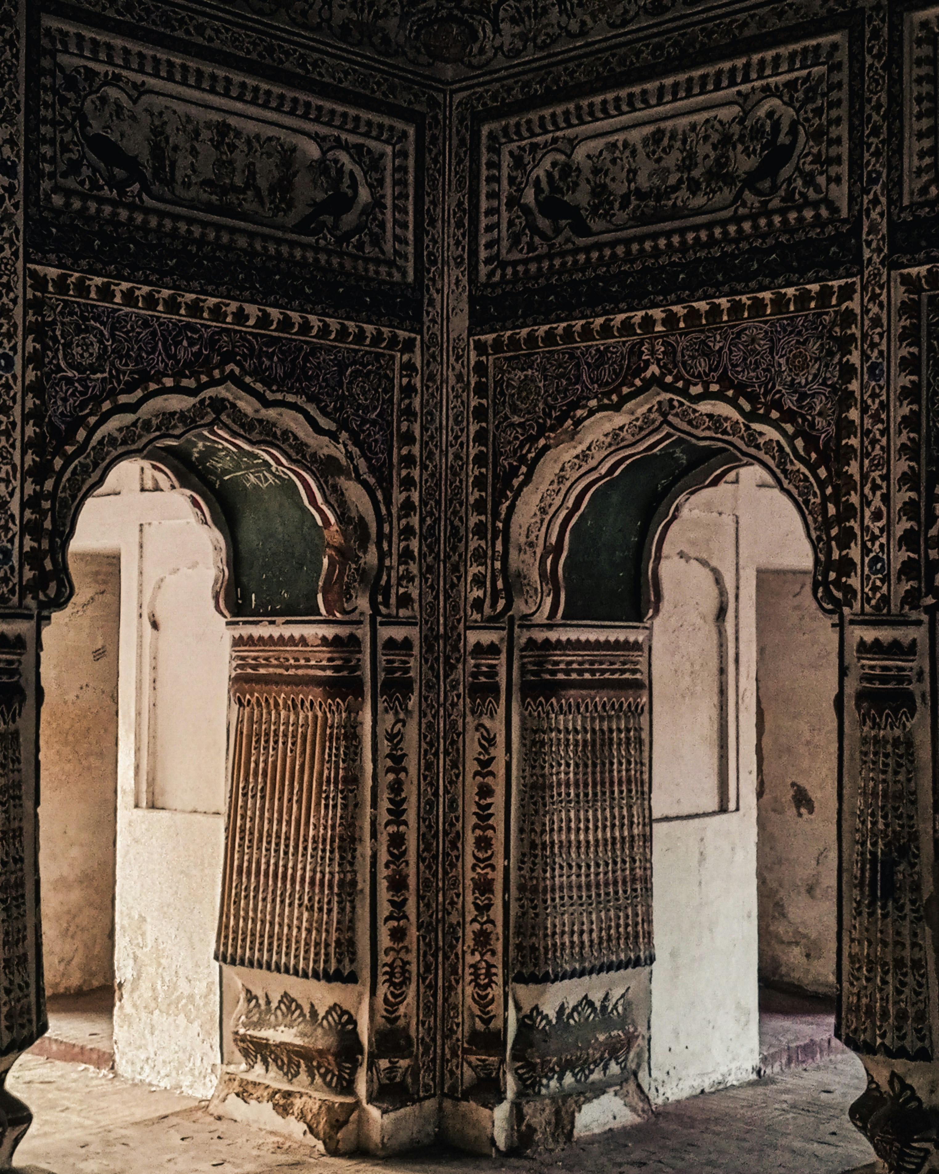 Intricate Carved Arches: Dim Light in a Historic Courtyard