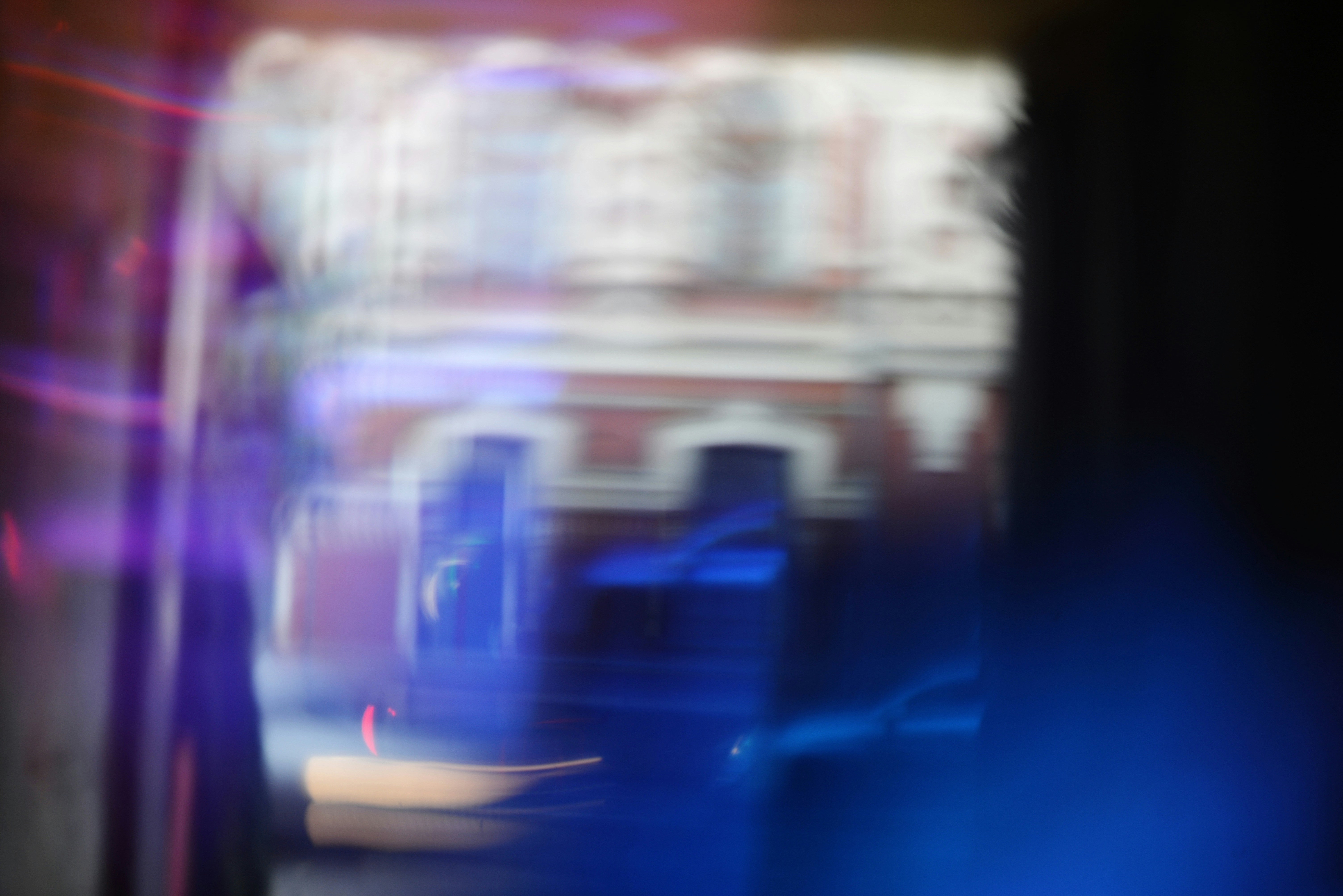 Blurred Facade in Neon Veil: City Lights Reflected in a Moving Frame