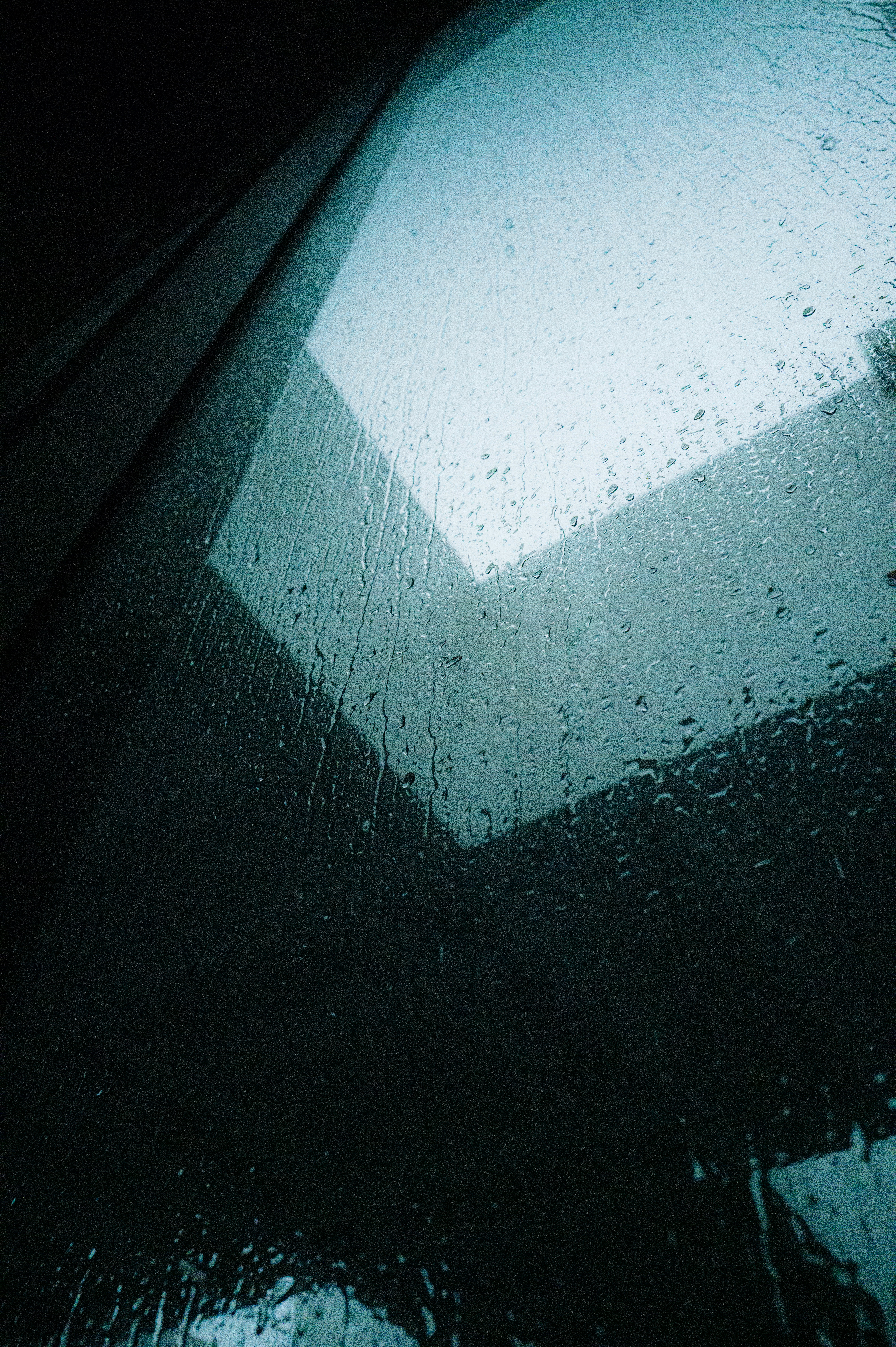 Urban Rain: Glass Facade Reflections through a Wet Window