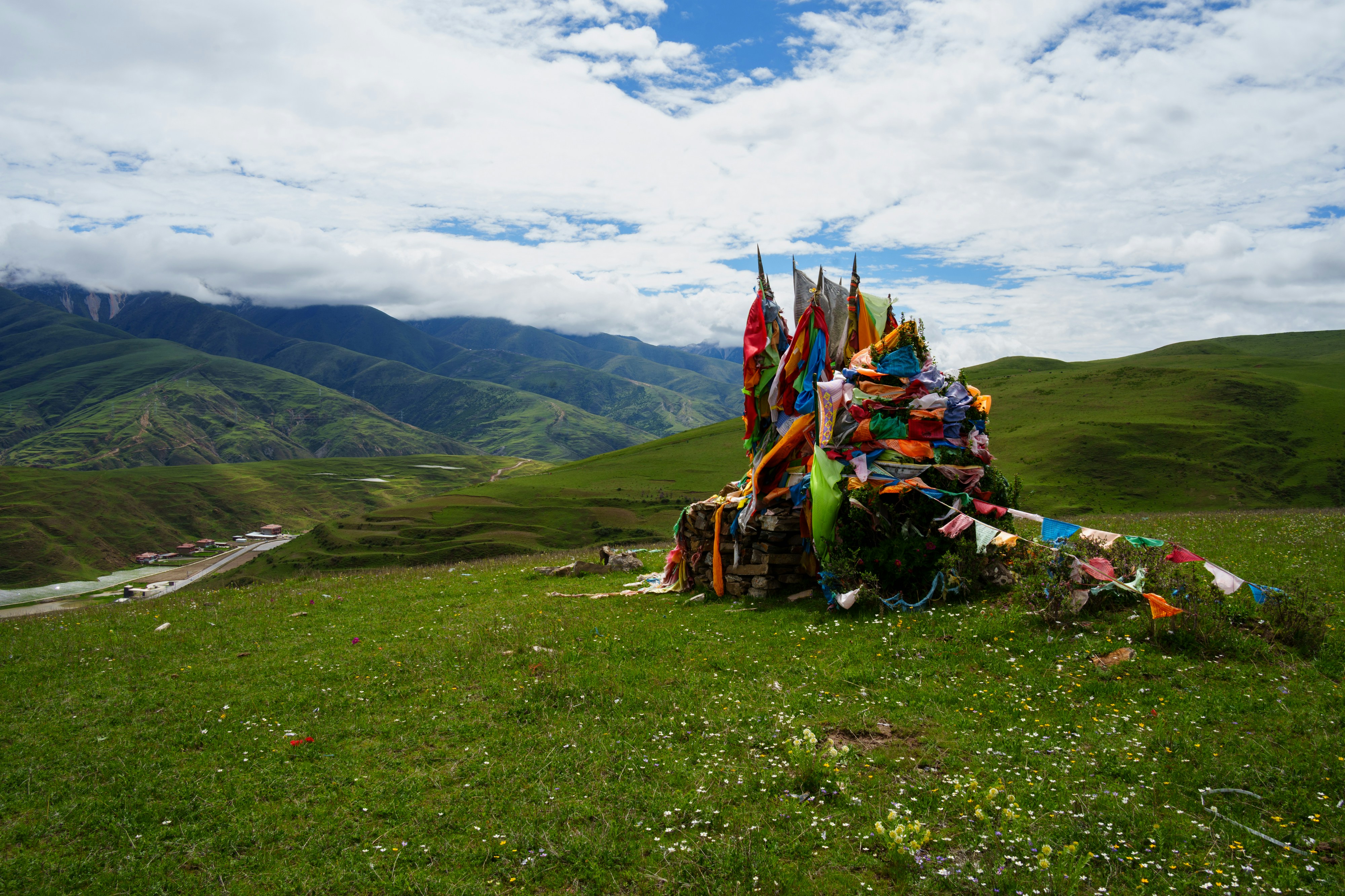 Prayer Flags on a Green Ridge Under a Wide Sky