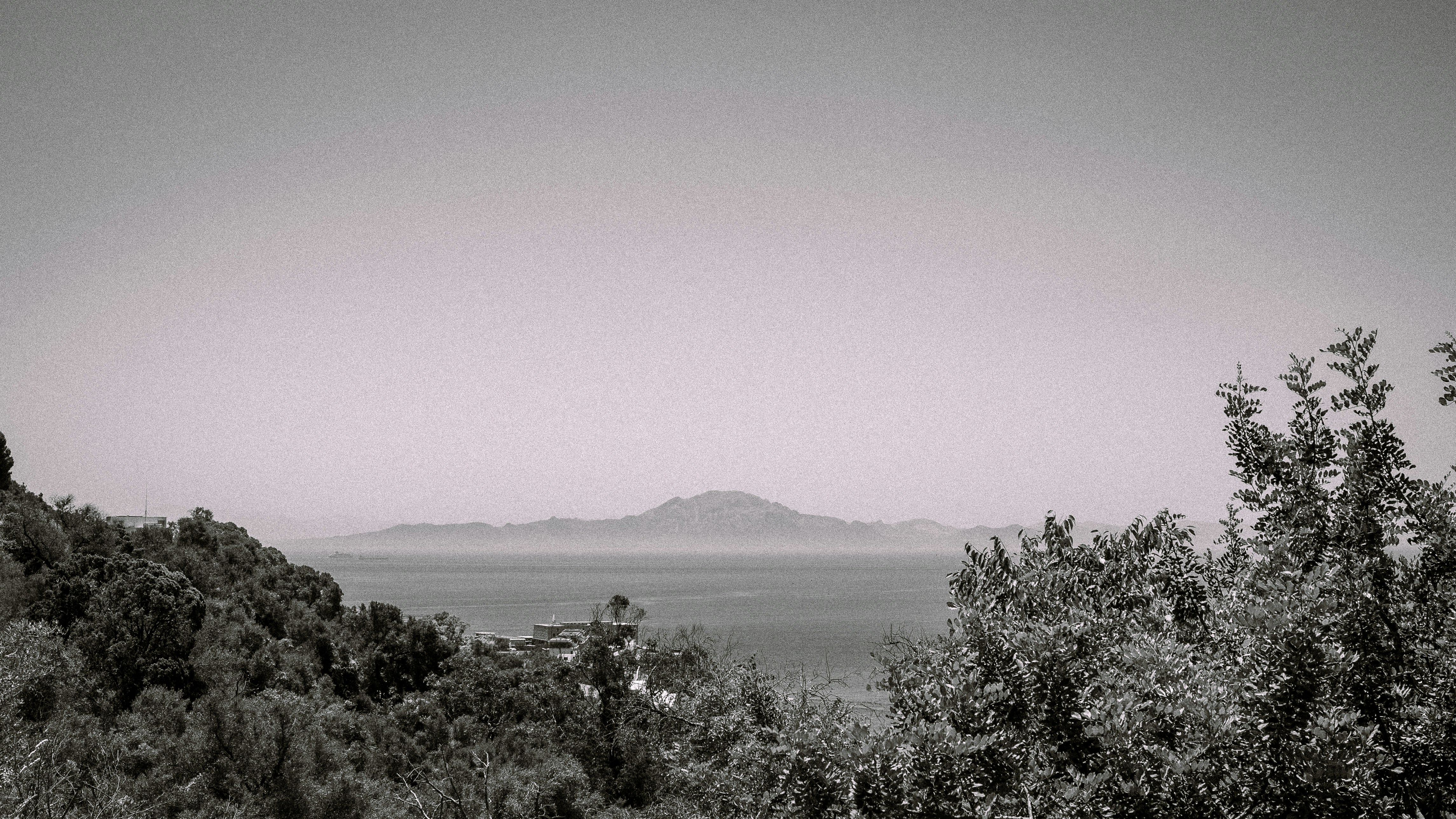 Island in the Haze: A Quiet Sea Vista Across Distant Peaks