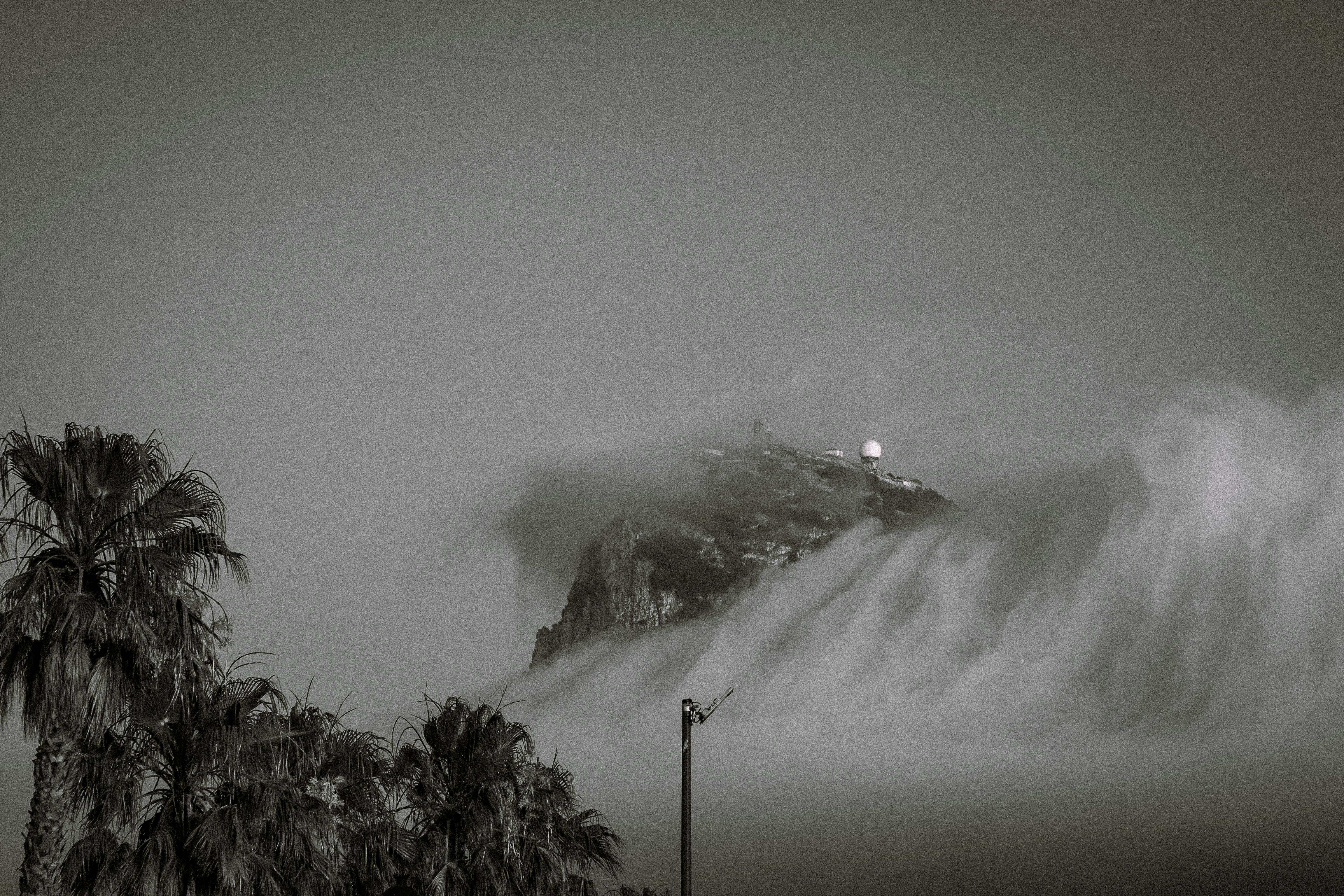 Mist on the Promontory: A Lone Lighthouse Emerges from the Surge