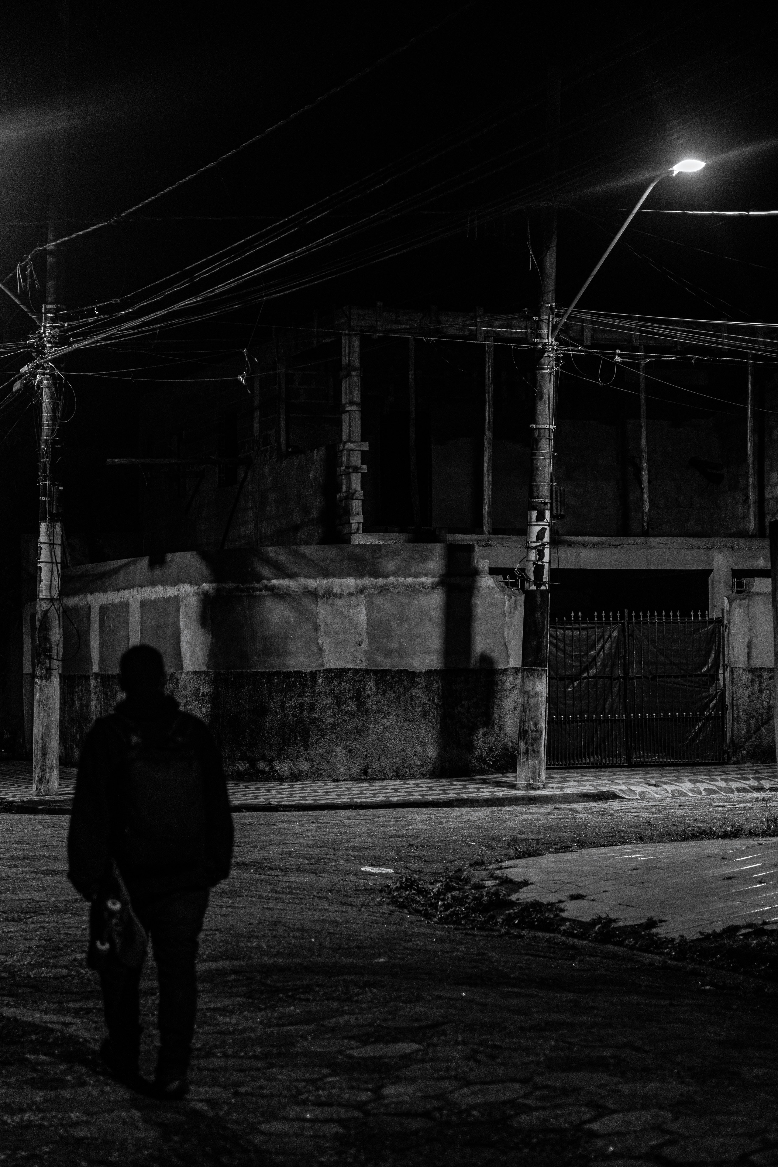 Silhouette under Neon Lines: A Quiet Street at Midnight