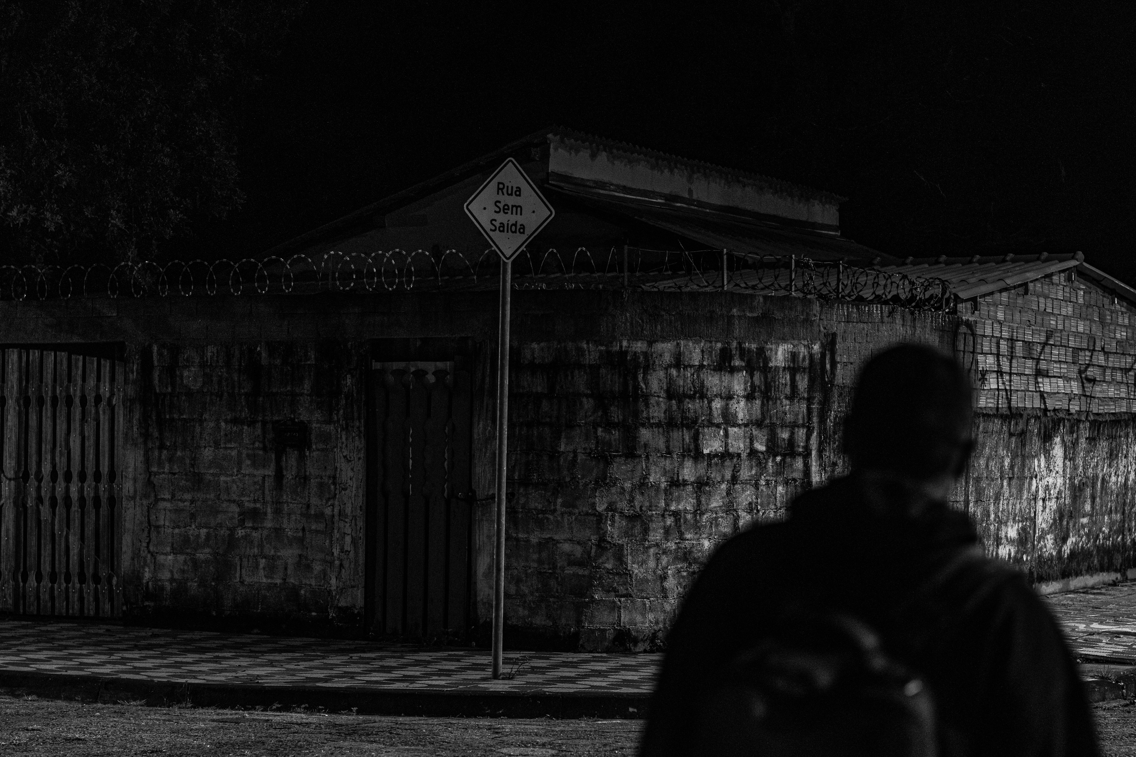 Night Corridor: A silhouette in a quiet perimeter