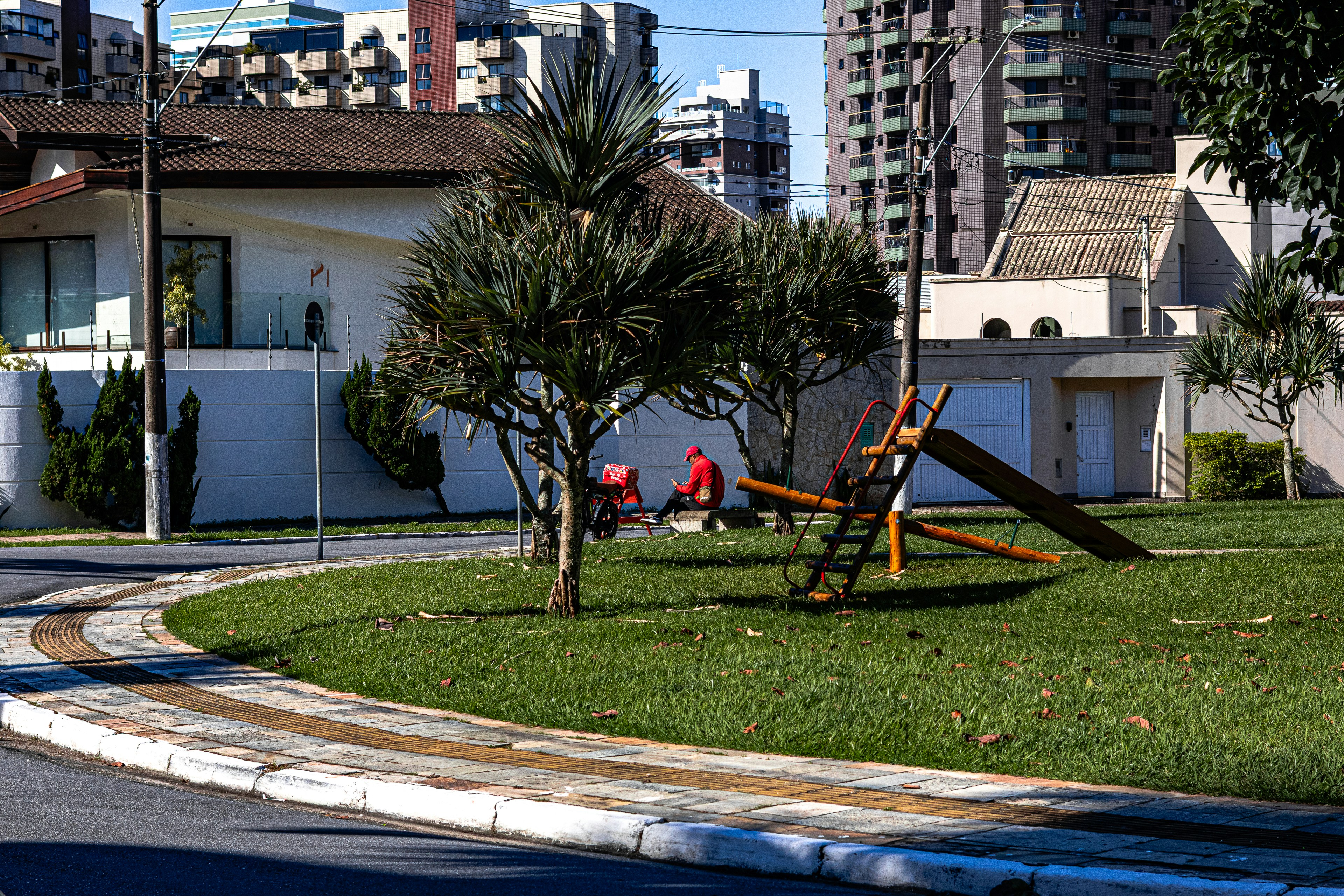Red-helmeted workers and playground under urban skyline