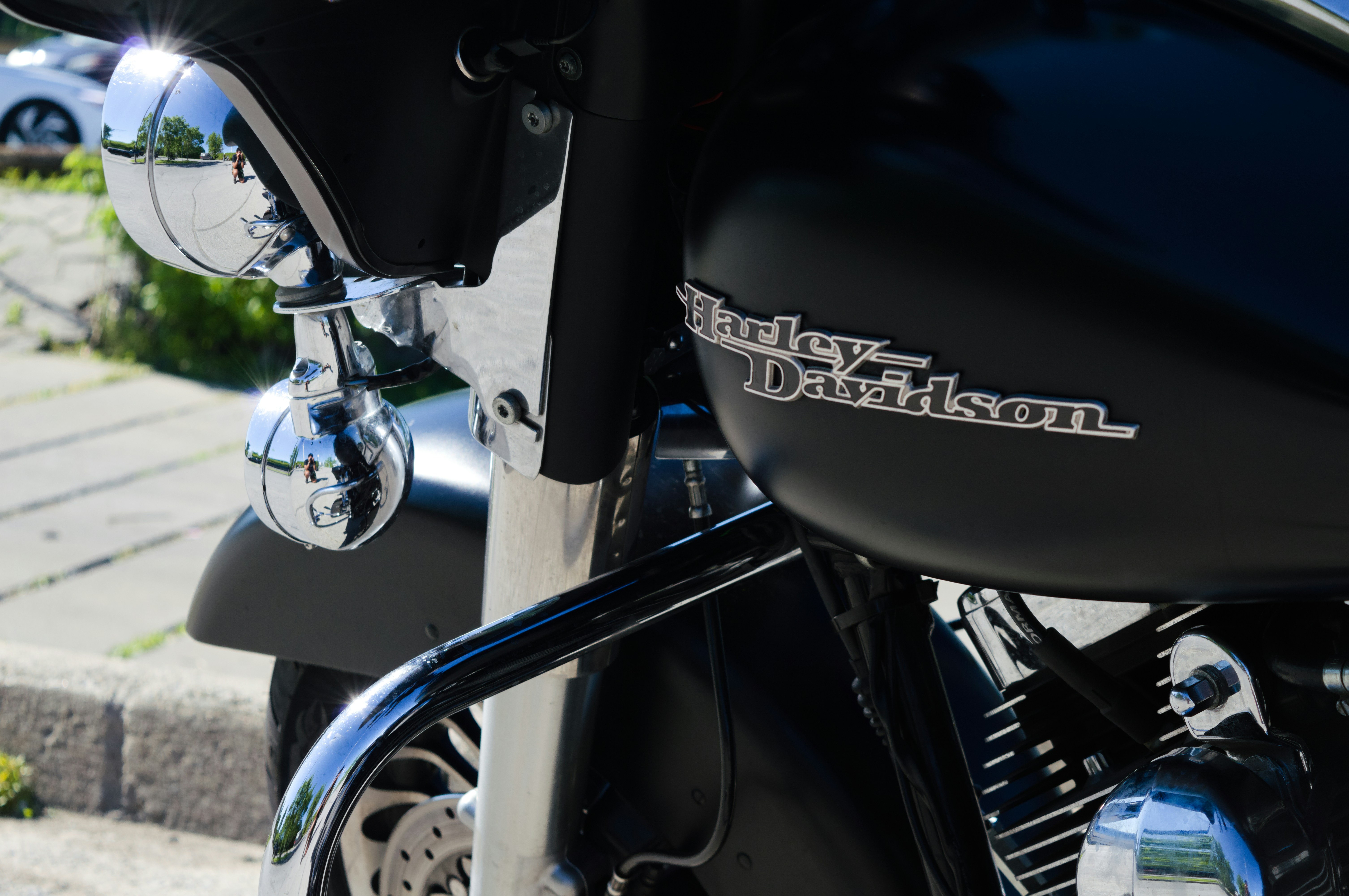 Chromed Contours: Close-Up of a Harley’s Emblem and Engine Detail