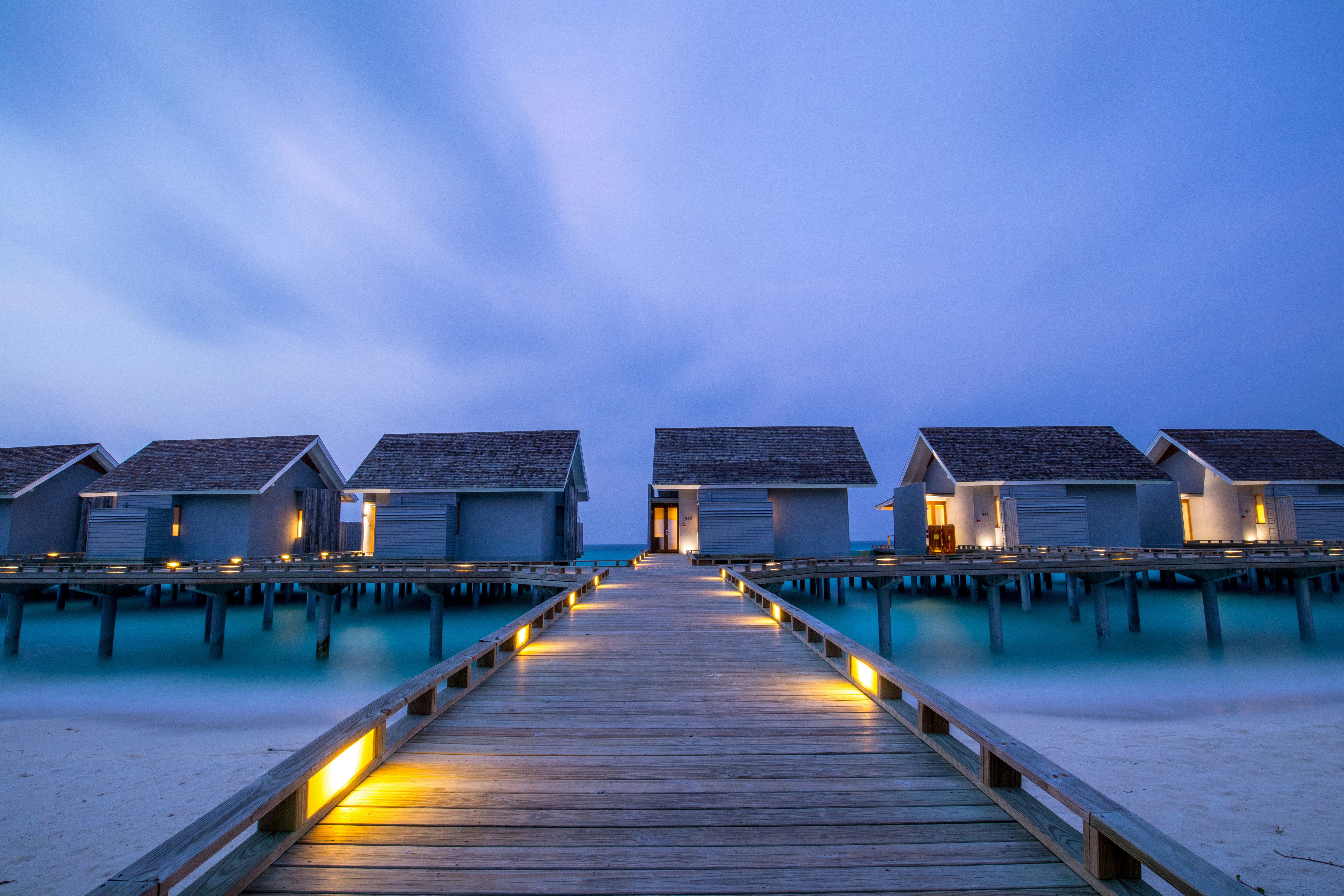 Lantern-lit Passage to Seaside Cabins at Blue Hour