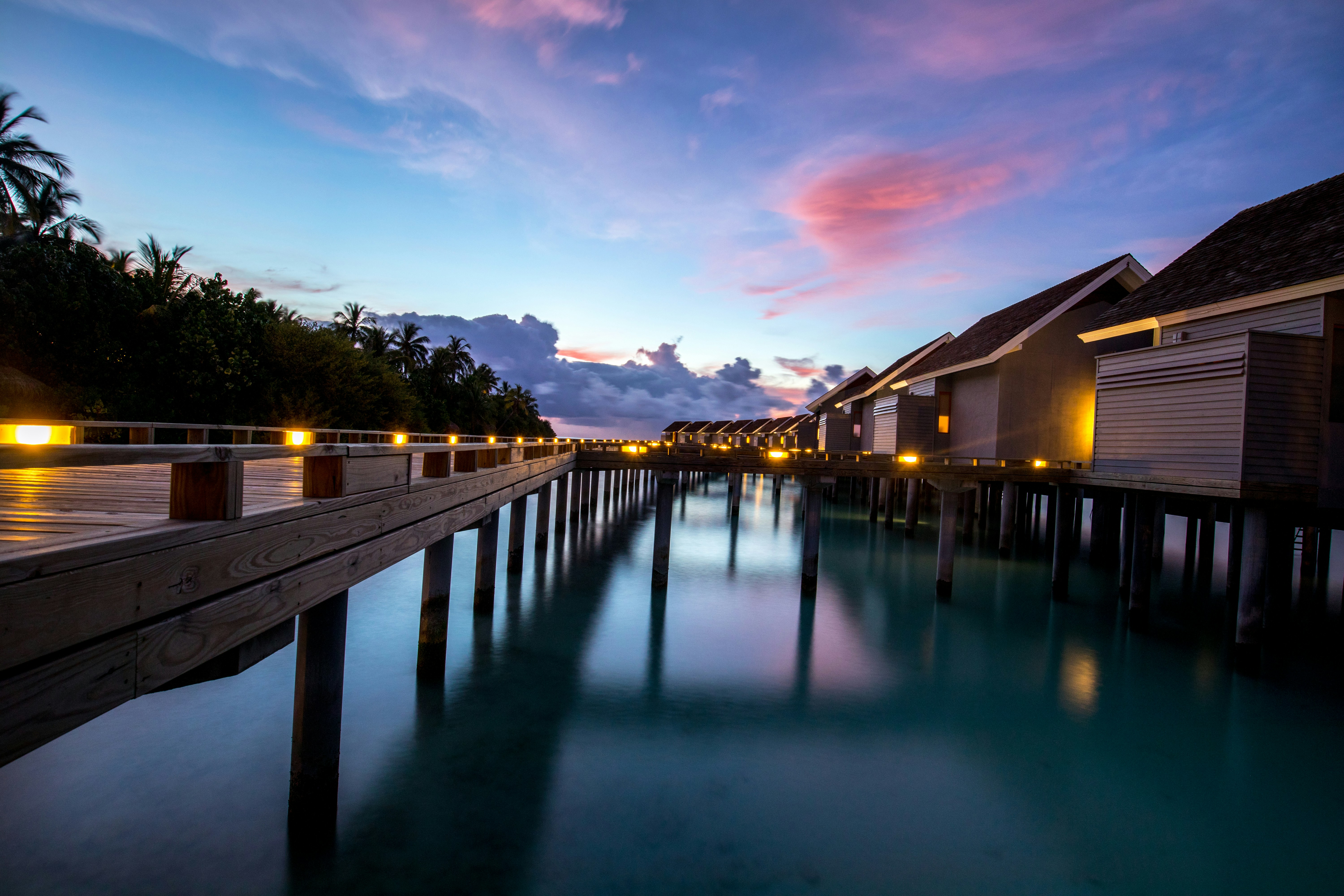 Sunset over crystal waters: Aboard a stilted resort pier