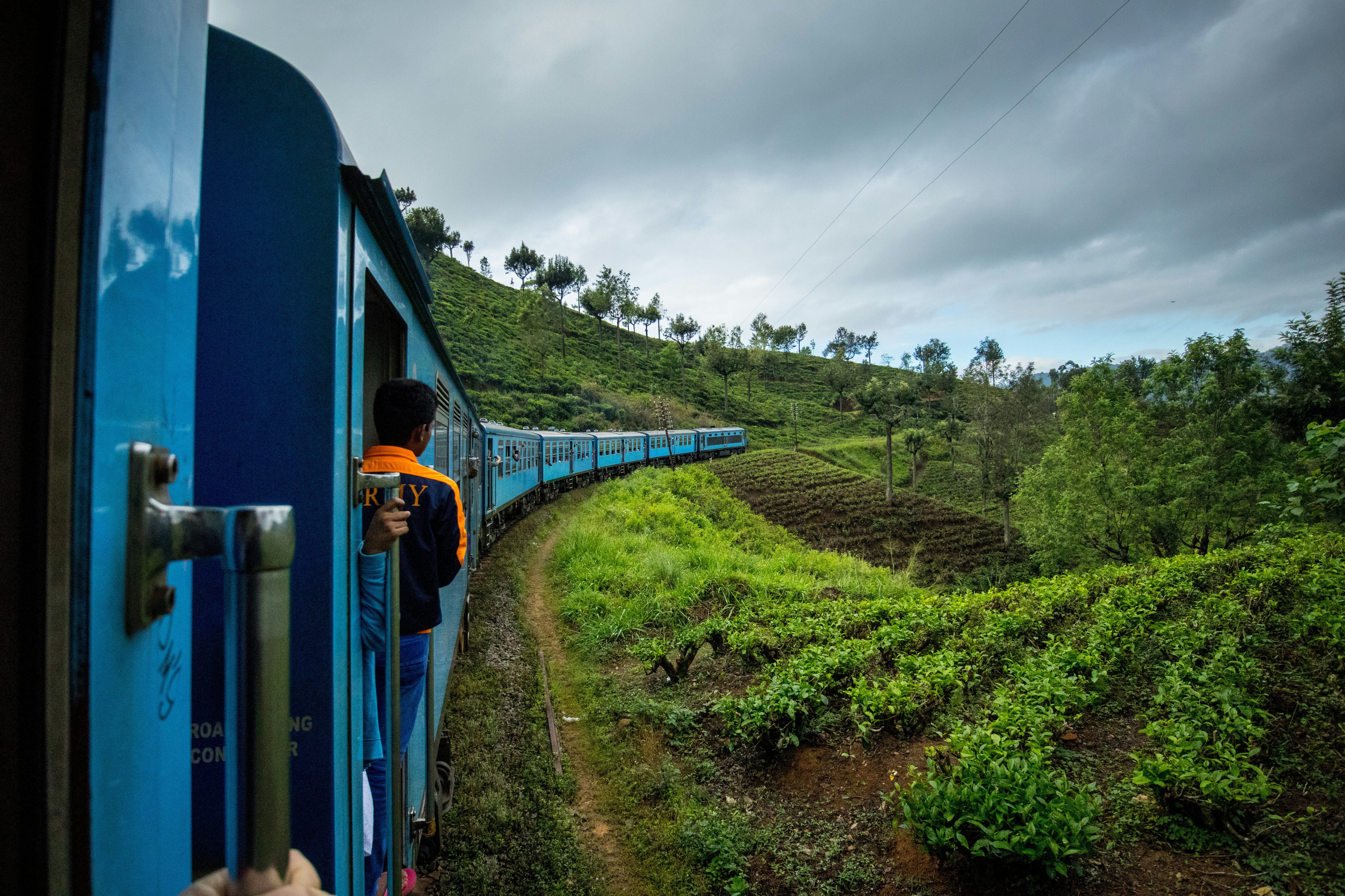 Blue Steam of the Hills: Passenger Train Rounding a Verdant Bend