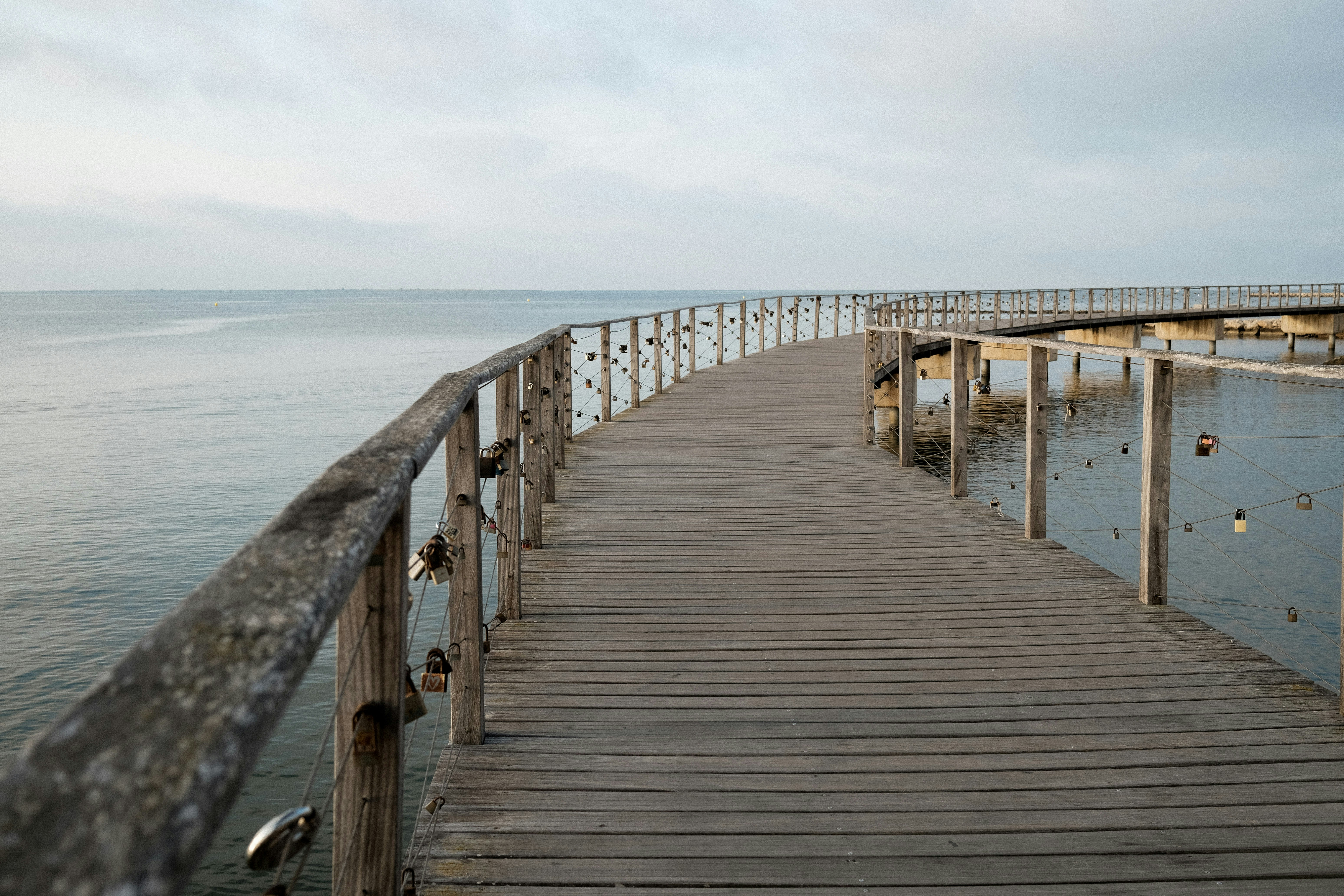 Curved Pier into a Quiet Sea