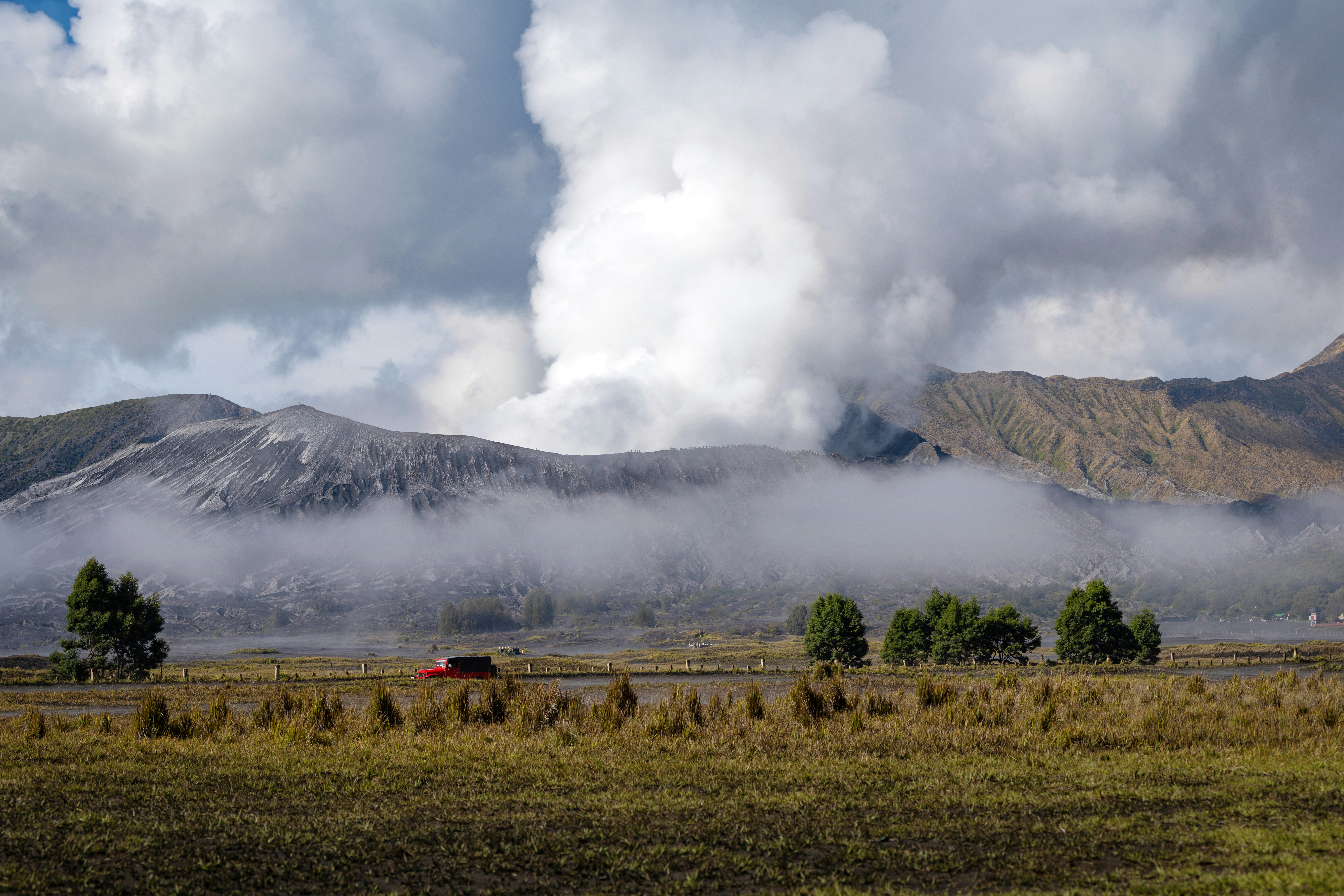 Steam over the Plains: A Red Truck Among Dawn Mist