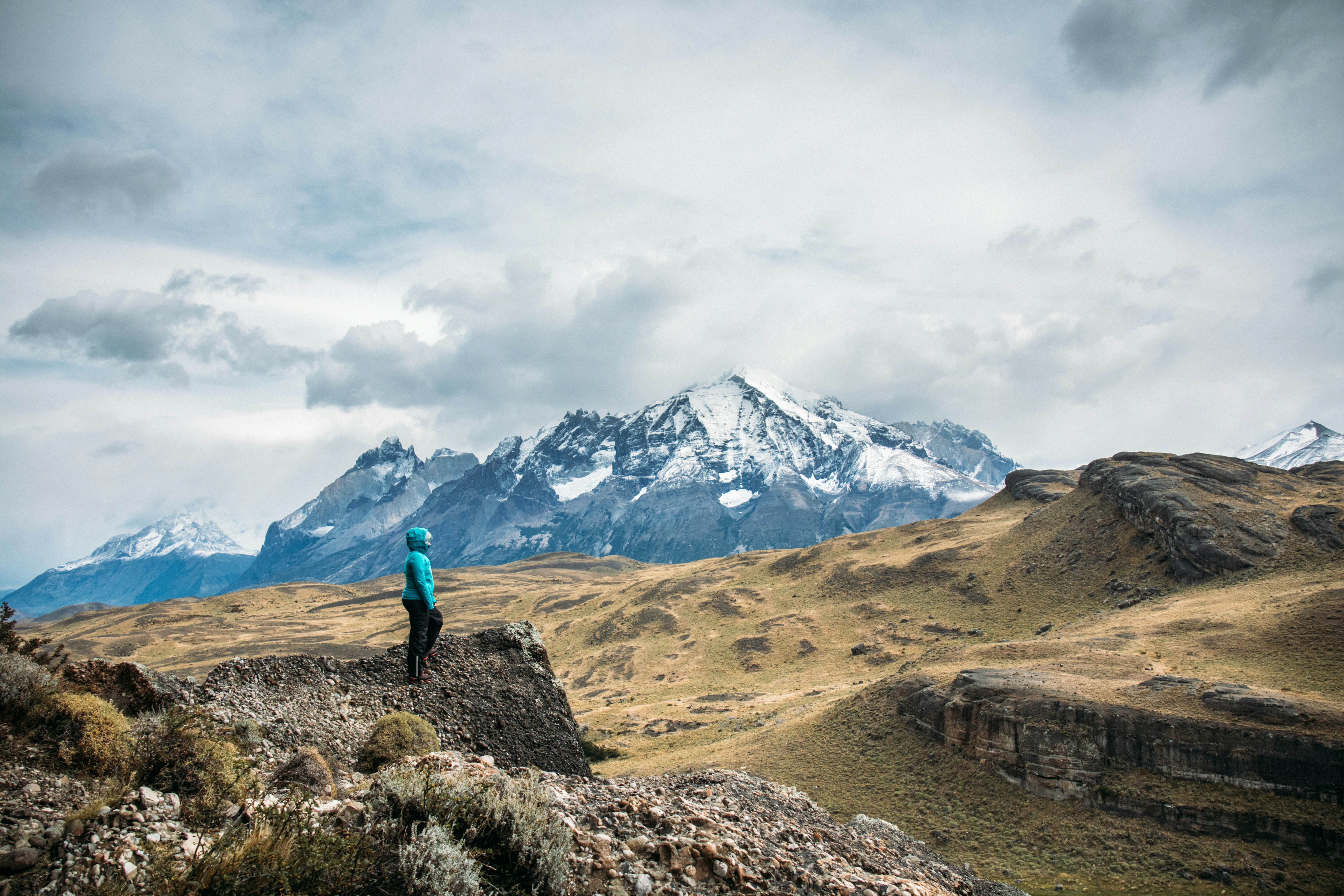 Horizon Walker on Weathered Ridge Beneath Snow-Capped Peaks