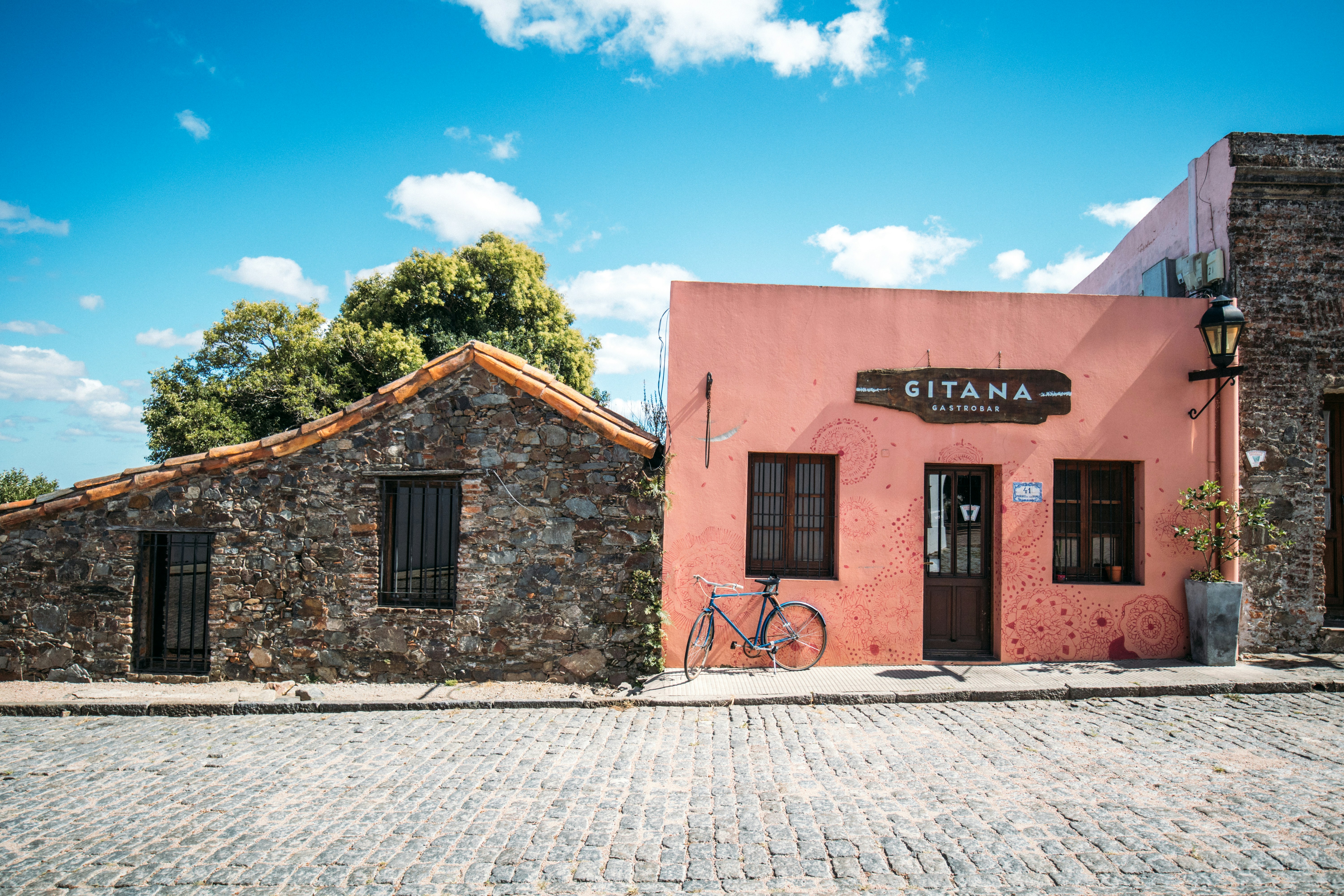 Sunlit pink café facade with a lone bicycle