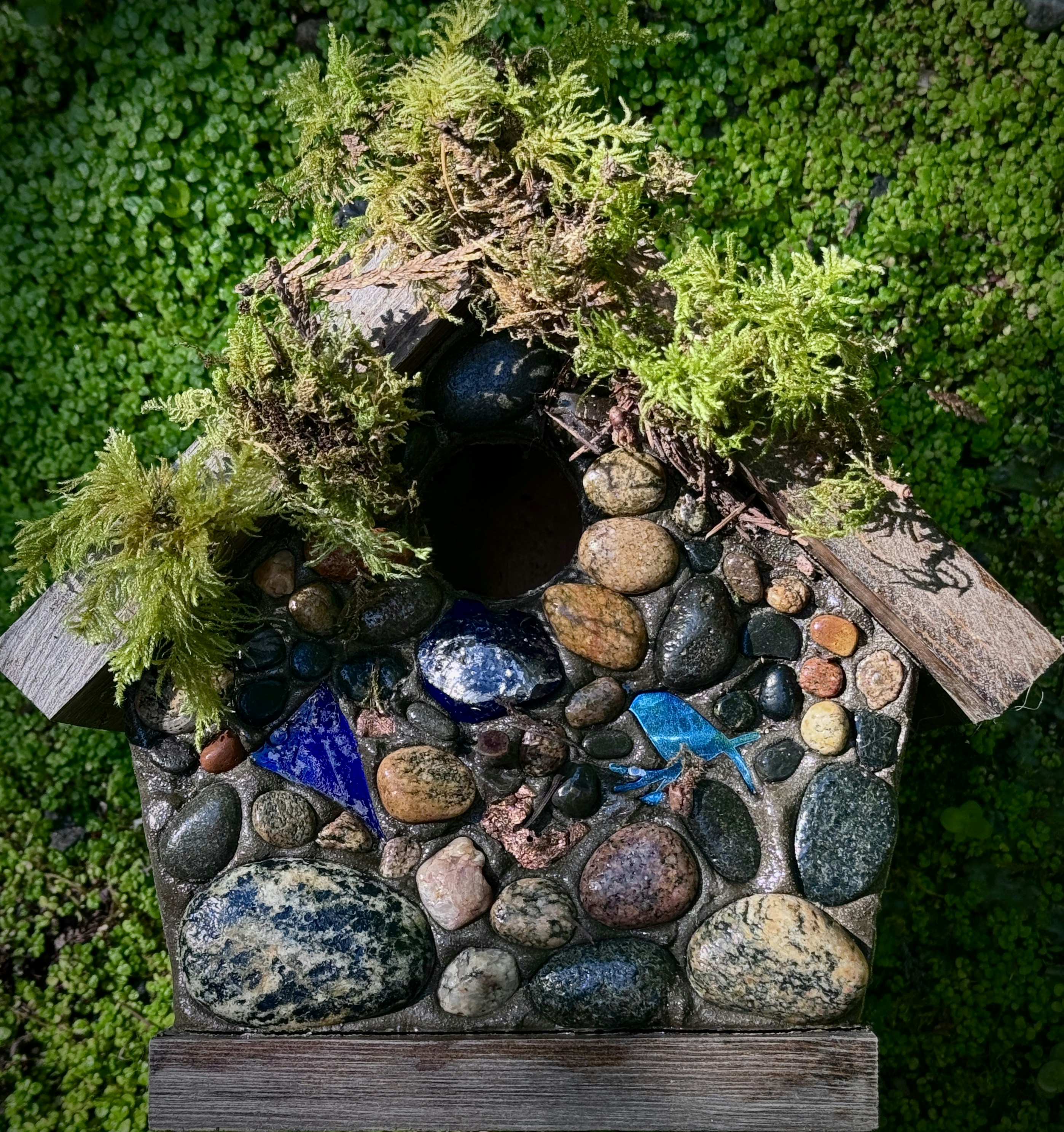 Stonelike Heartboard: A Pebble Mosaic Birdhouse Emerges from Greenery
