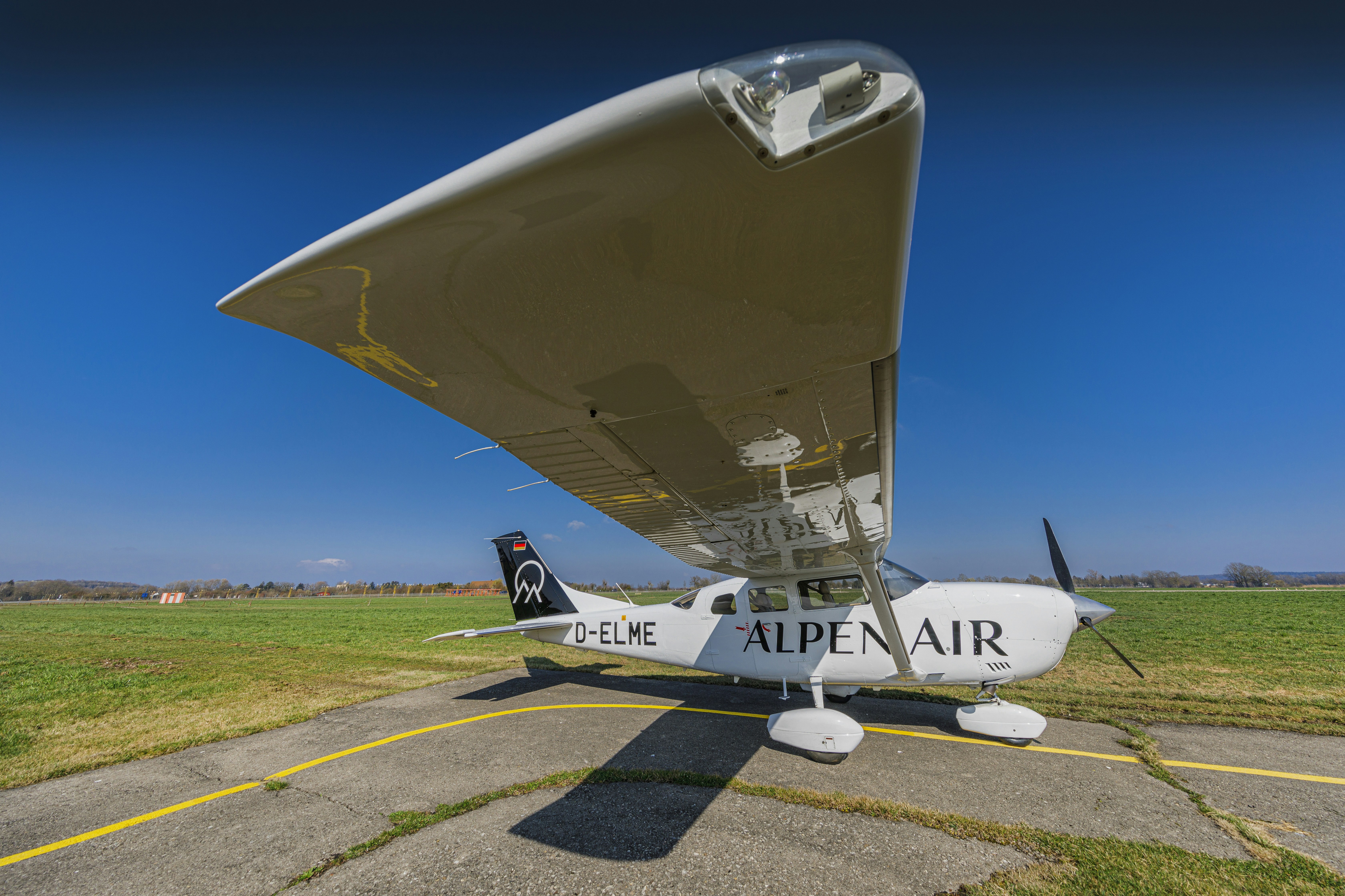 Winged silhouette: a light aircraft parked on a sunlit runway