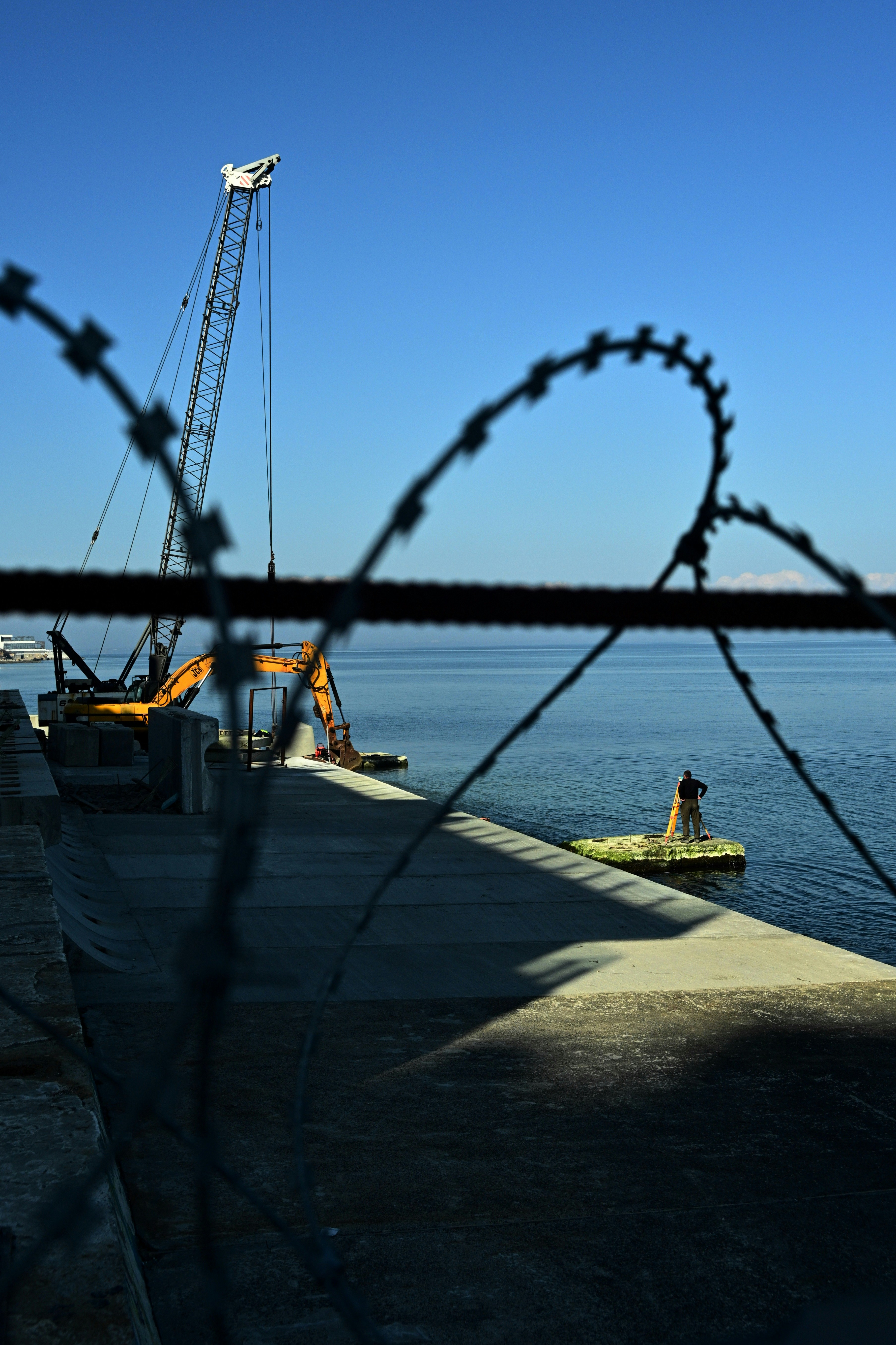 Harbor Construction at Dusk: Barbed Shadows and Rising Crane