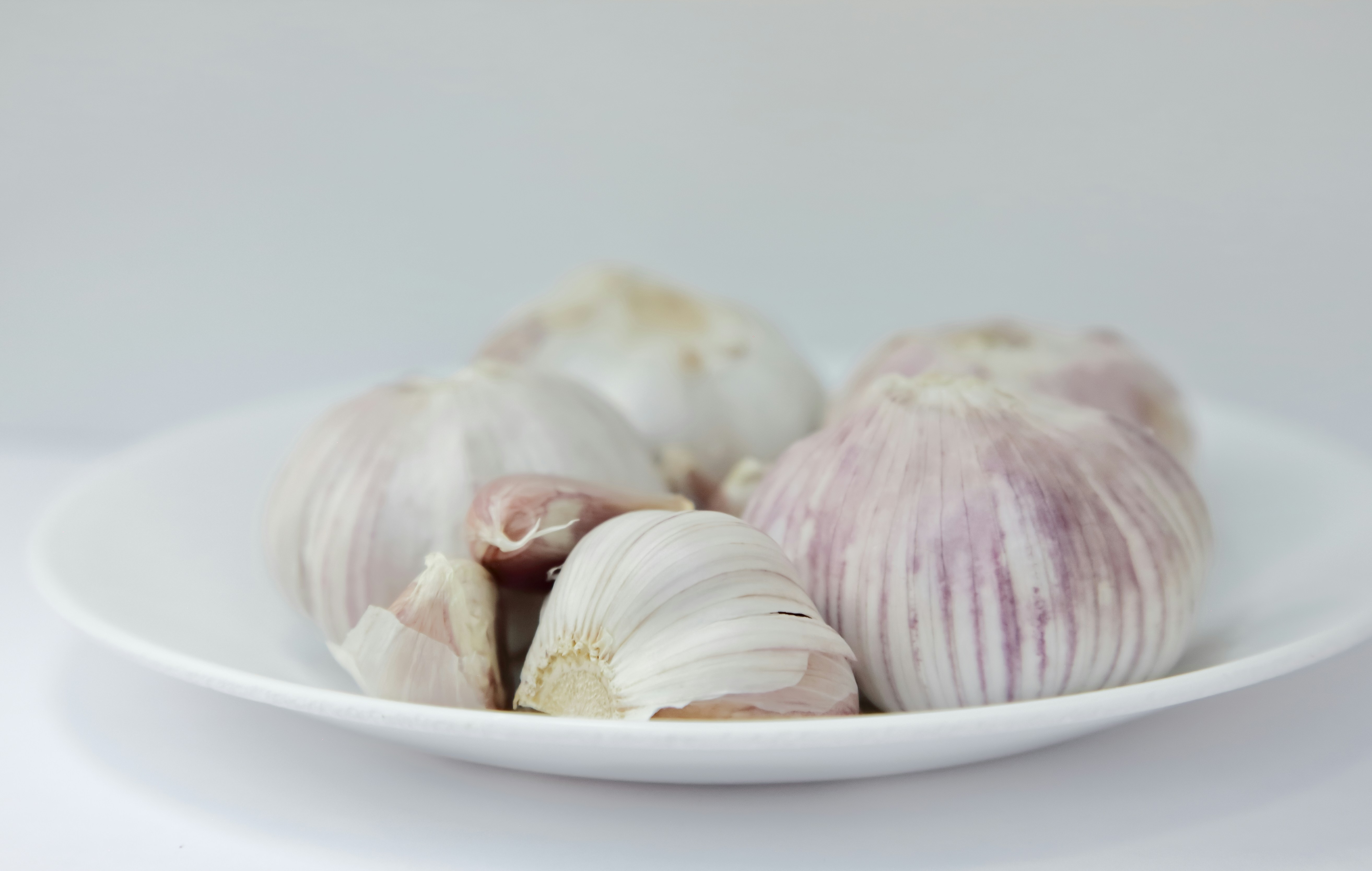 Soft-Glow Garlic: Pearled Heads on a White Plate