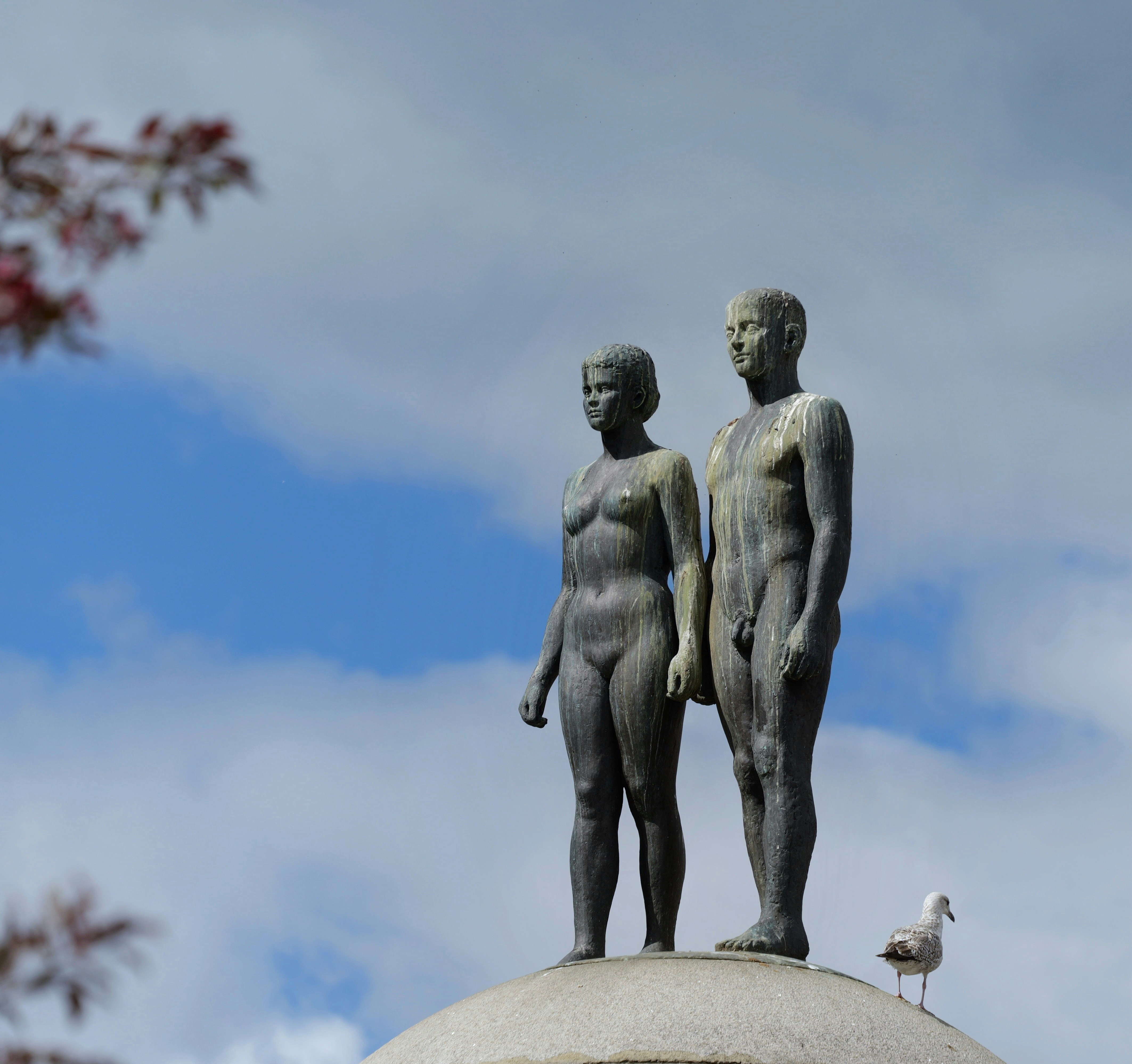 Sculpted guardians atop a pedestal under a blue sky