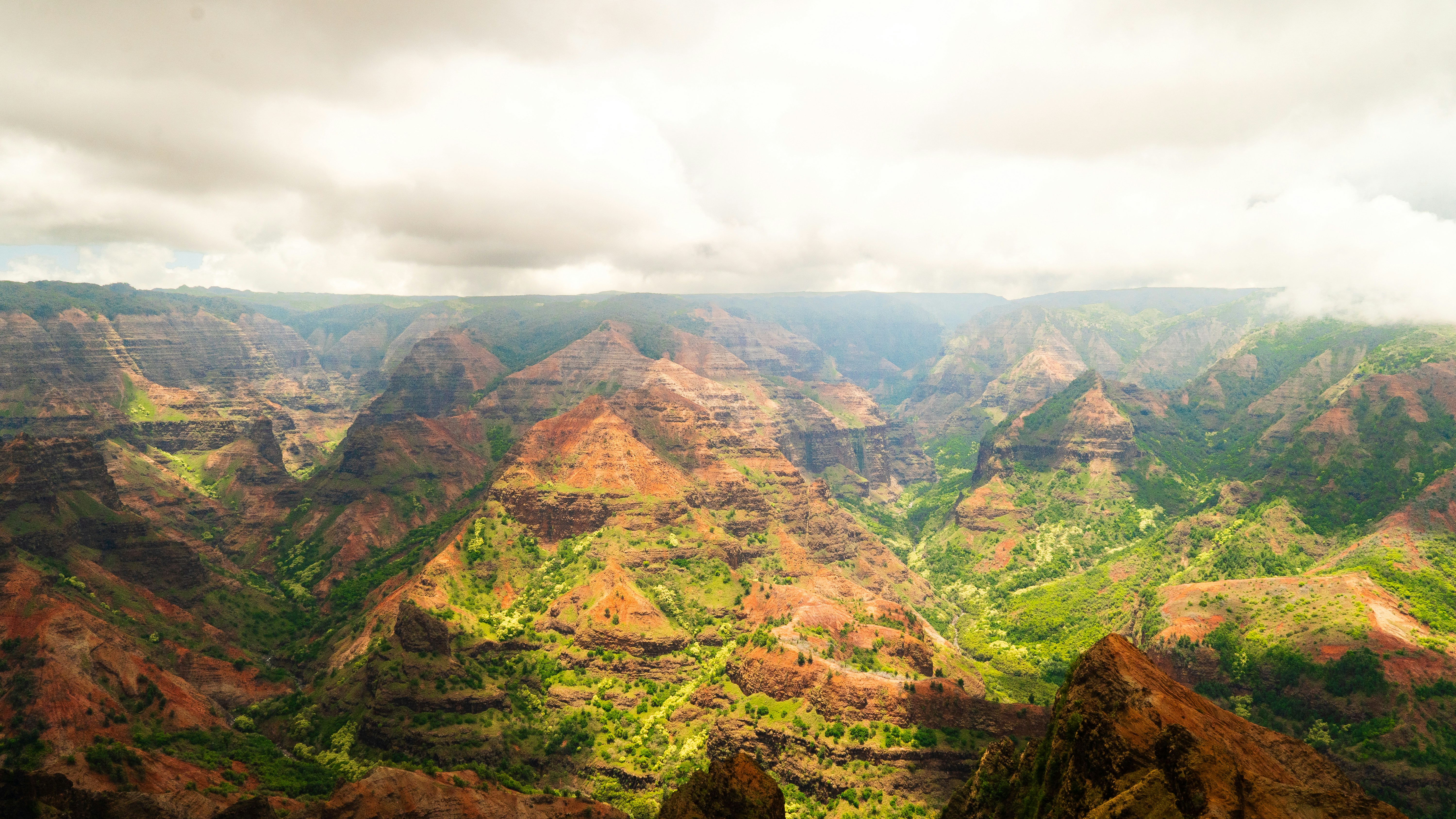 Rugged Canyon Echoes: A Vista Over layered Red and Green Cliffs