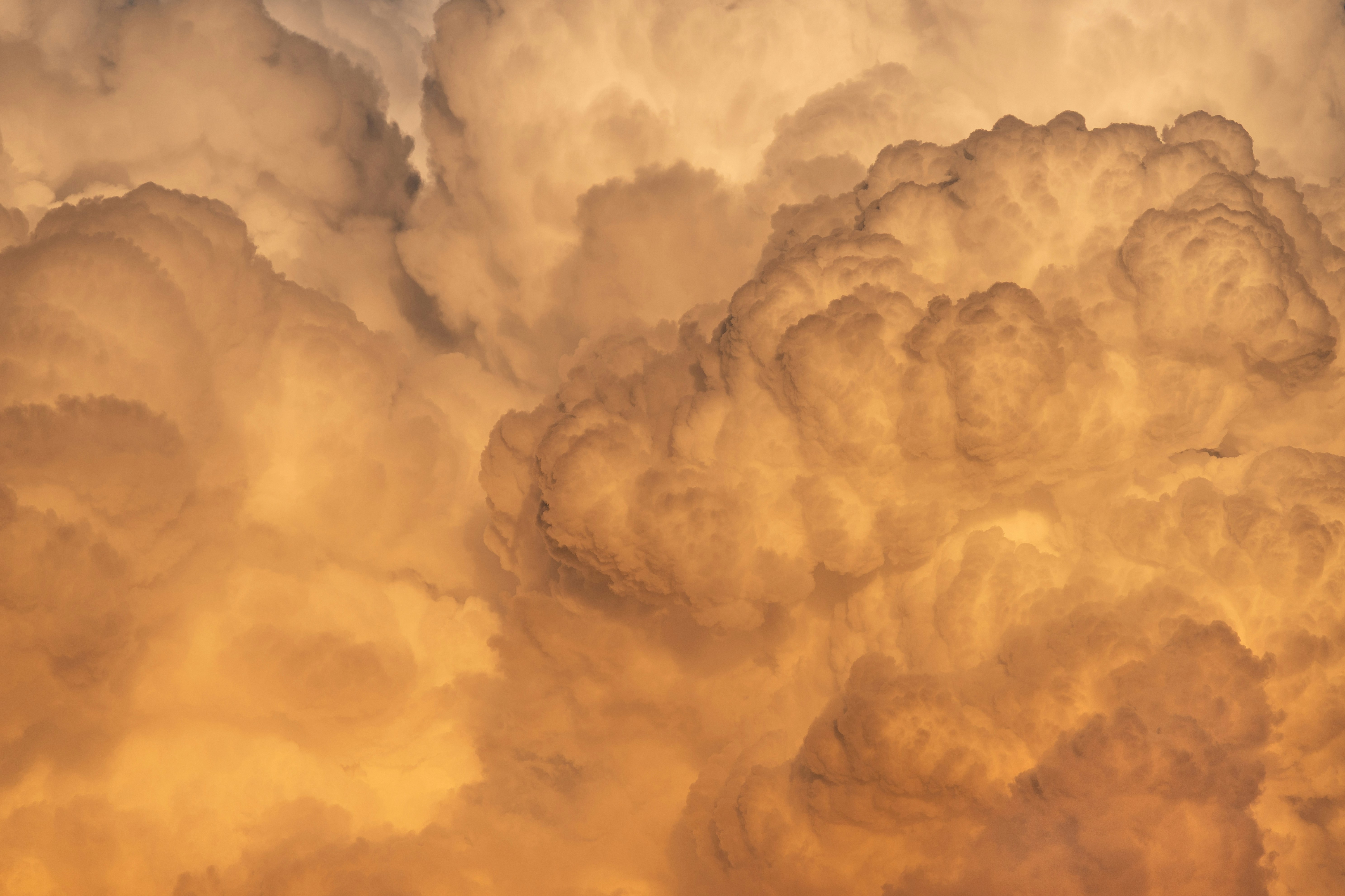 Sunlit Cloudscape: Golden Peaks Rising in Quiet Sky