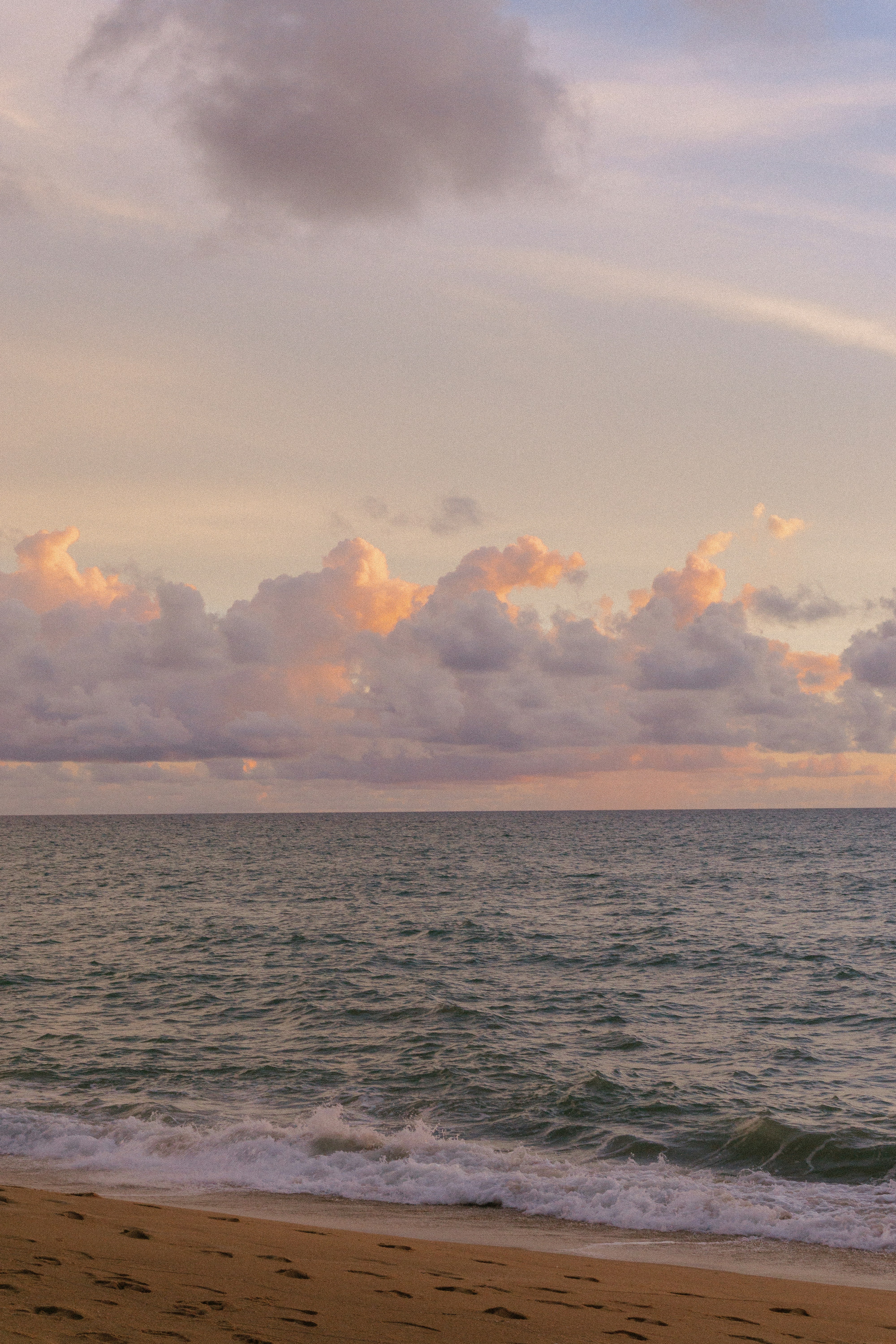 Dusk on the Quiet Shore: Gentle Waves and Soft Clouds