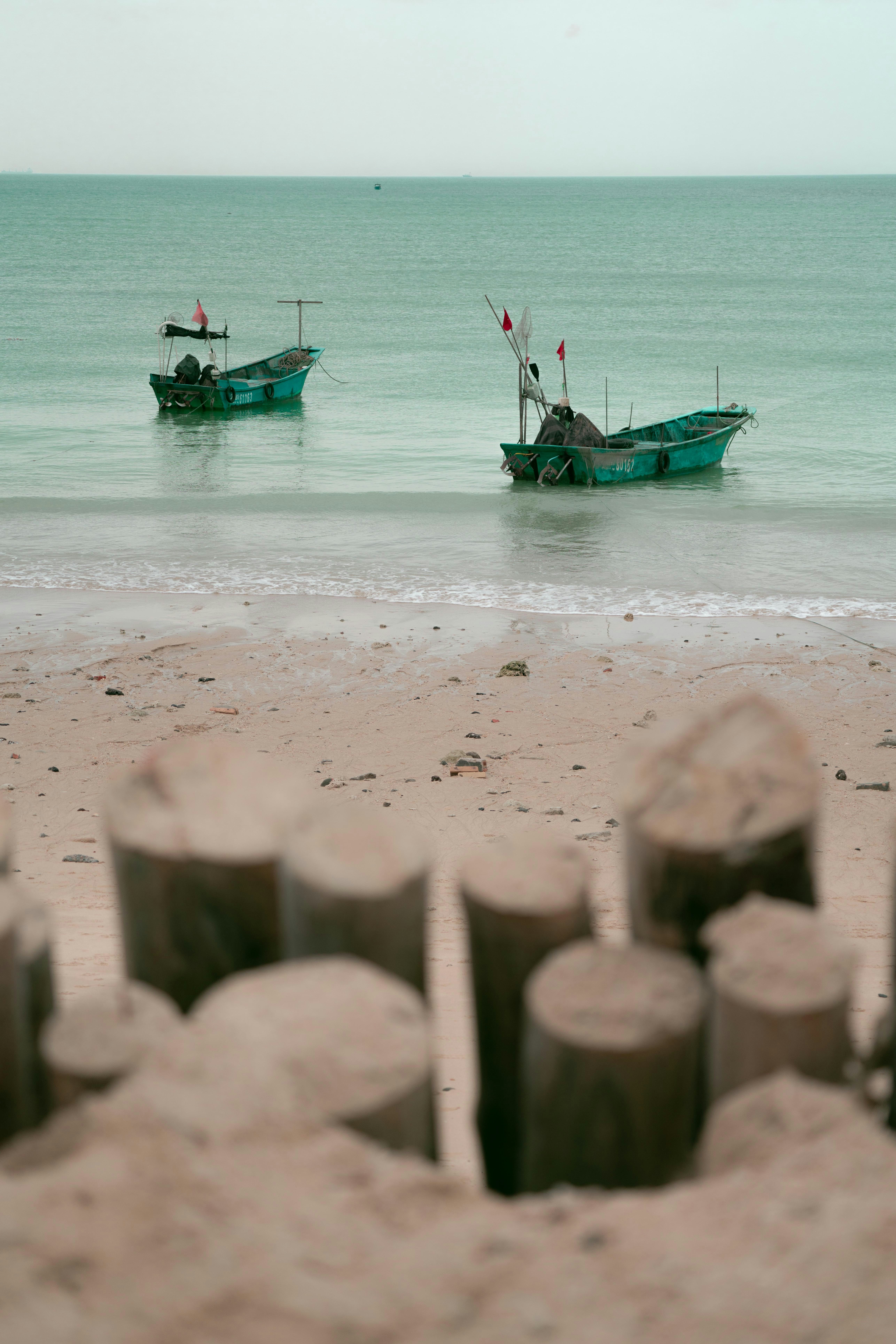 Two turquoise boats Rest on Quiet Coral Waves