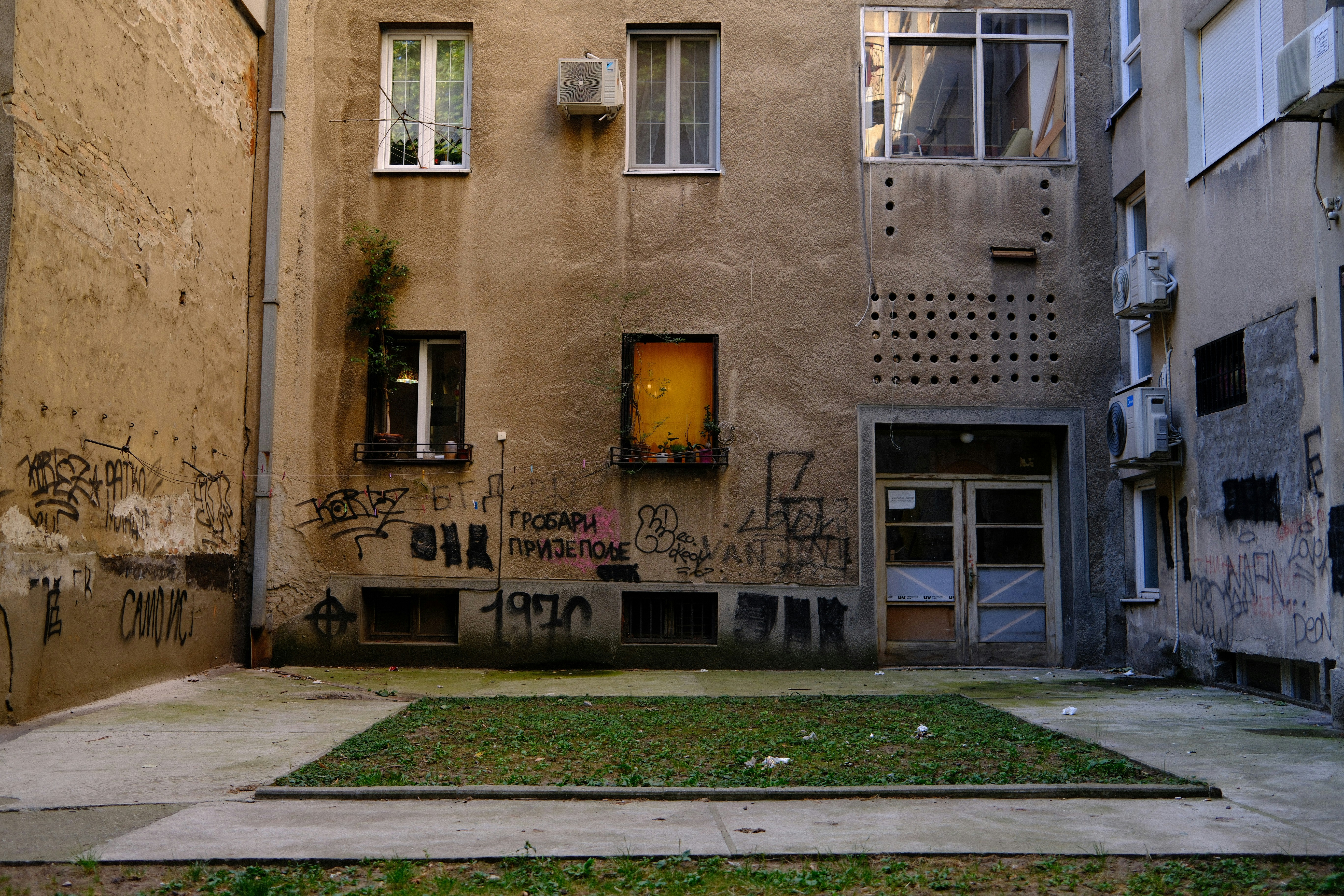 Graffiti-walled courtyard with a weathered building facade